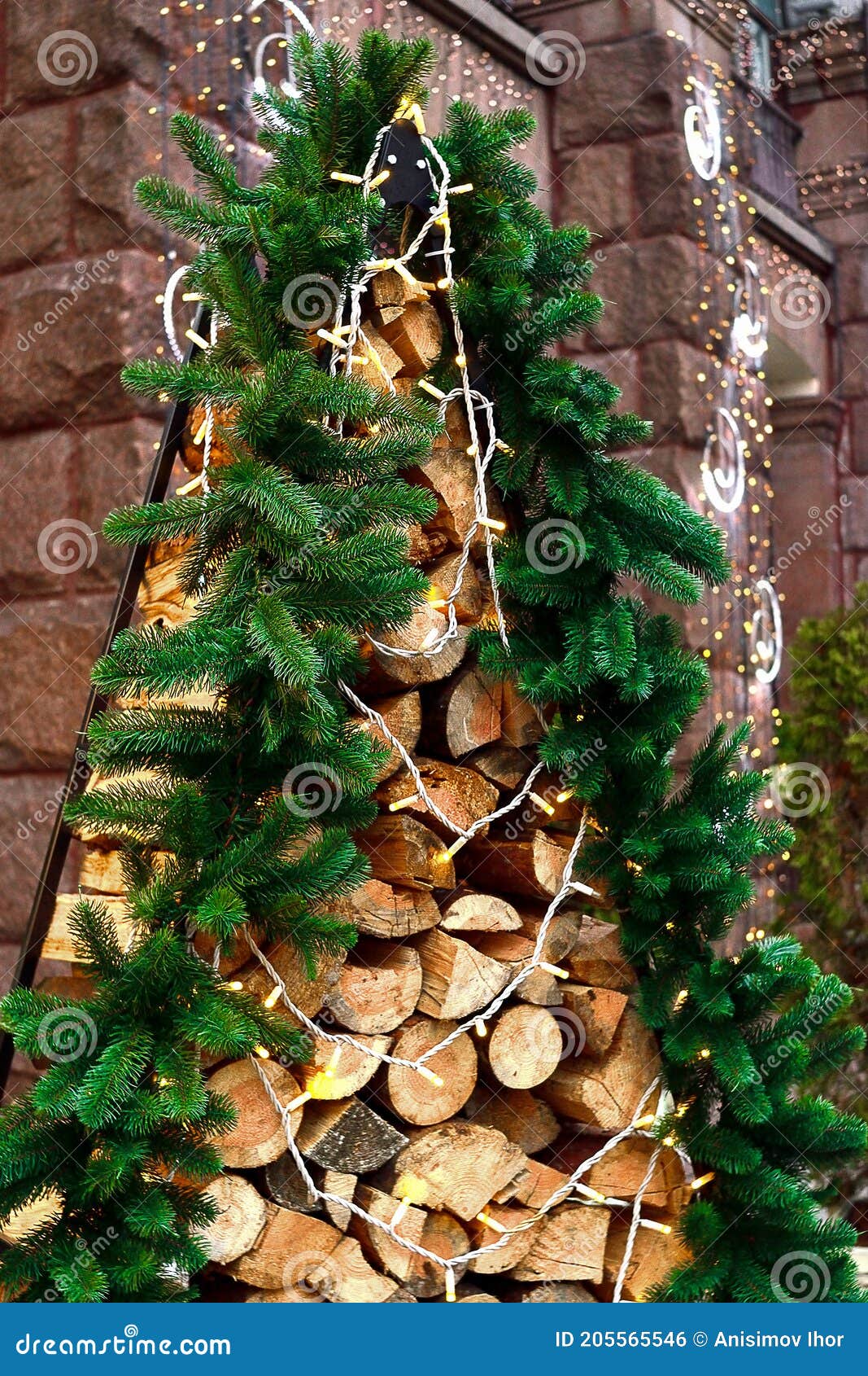 Creative Christmas Tree Made of Logs and Christmas Lights Stands on the ...