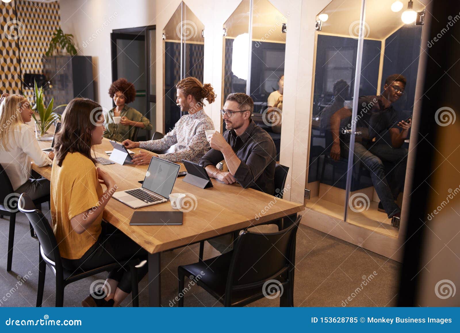 Creative Colleagues Sitting at a Table Socialising in Their Office ...