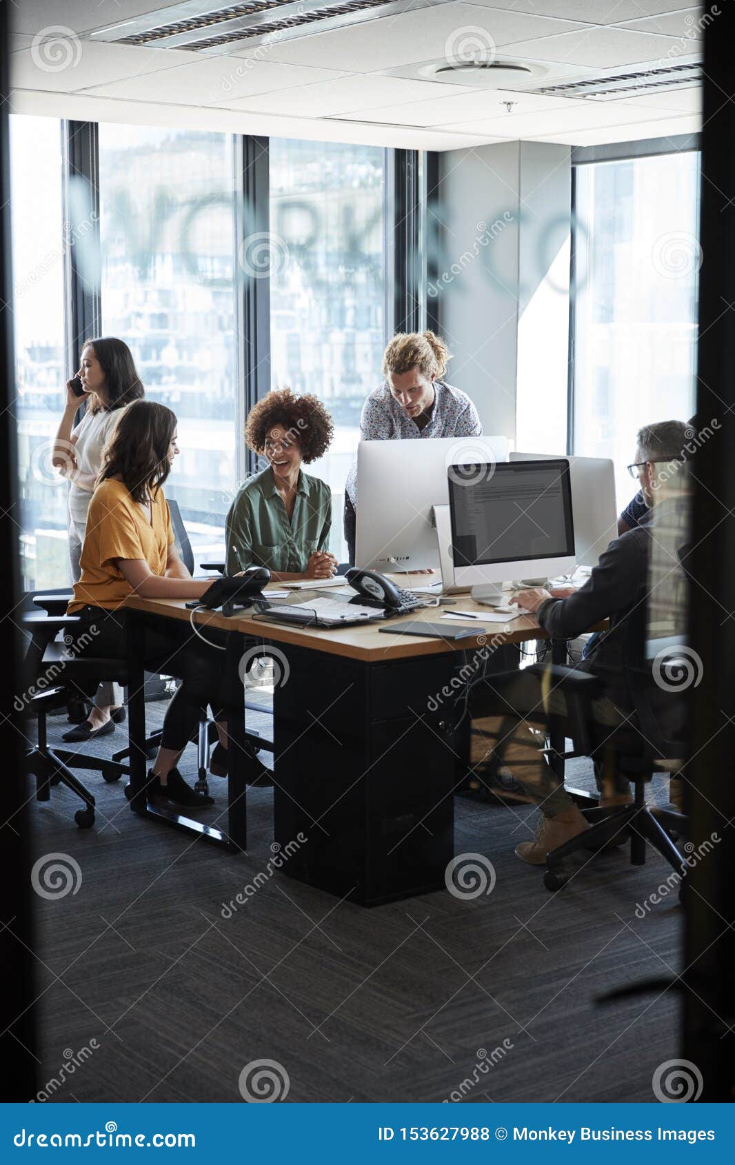 Creative Colleagues in Working in a Casual Office, Seen through Glass ...