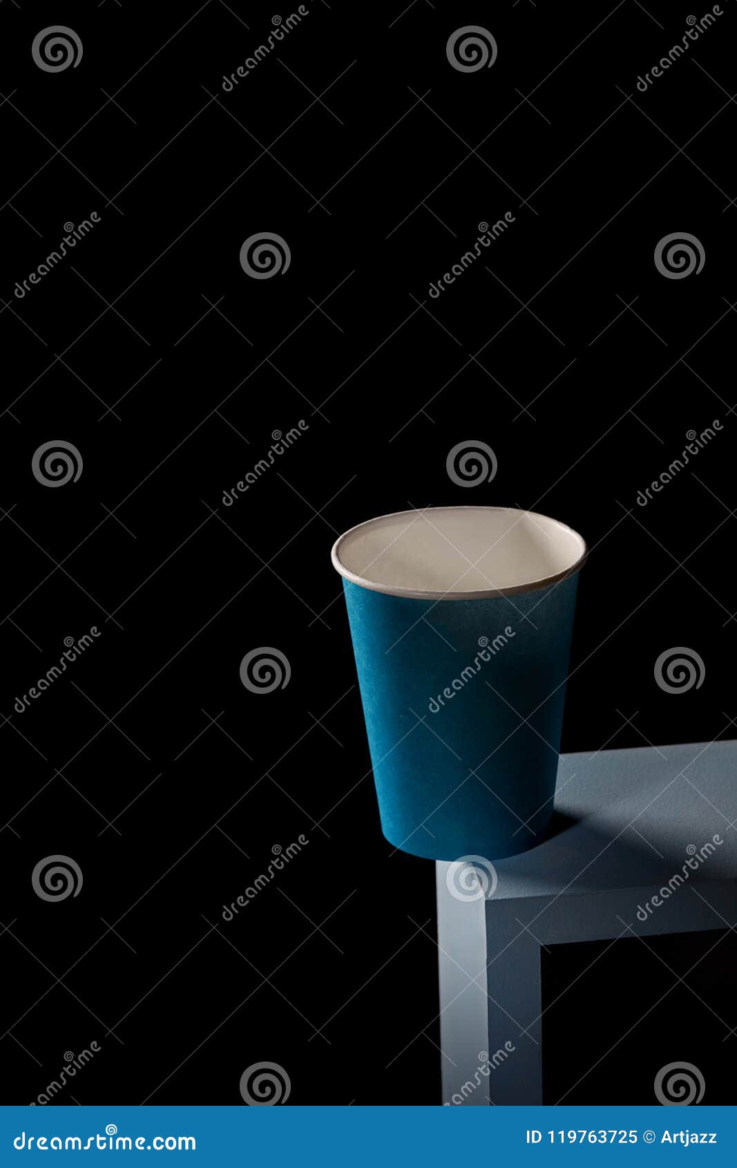 A Blue Paper Cup Stands on the Edge of a Blue Square Frame on a Black ...