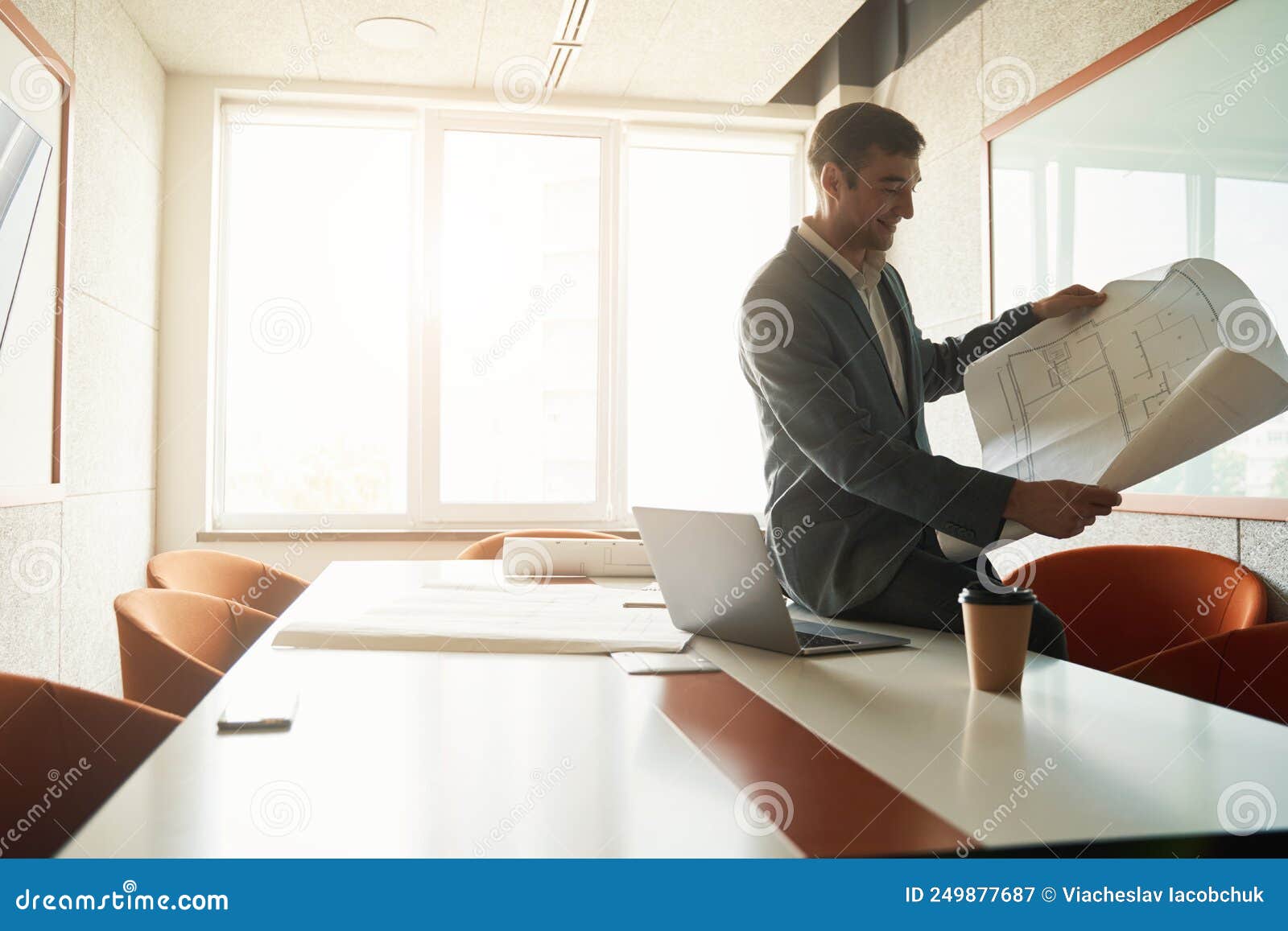 Creative Design Engineer Sitting on Table with Drawings in Hands Stock ...