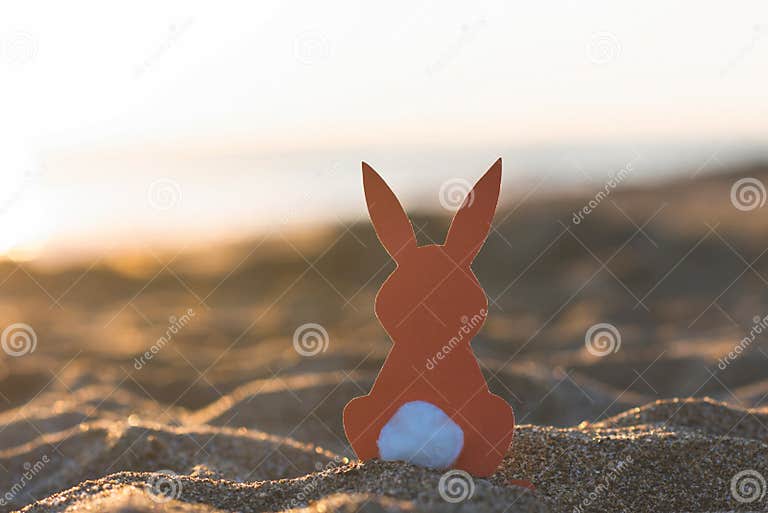 Creative Easter Concept Photo Of Red Paper Bunny On The Sand On The