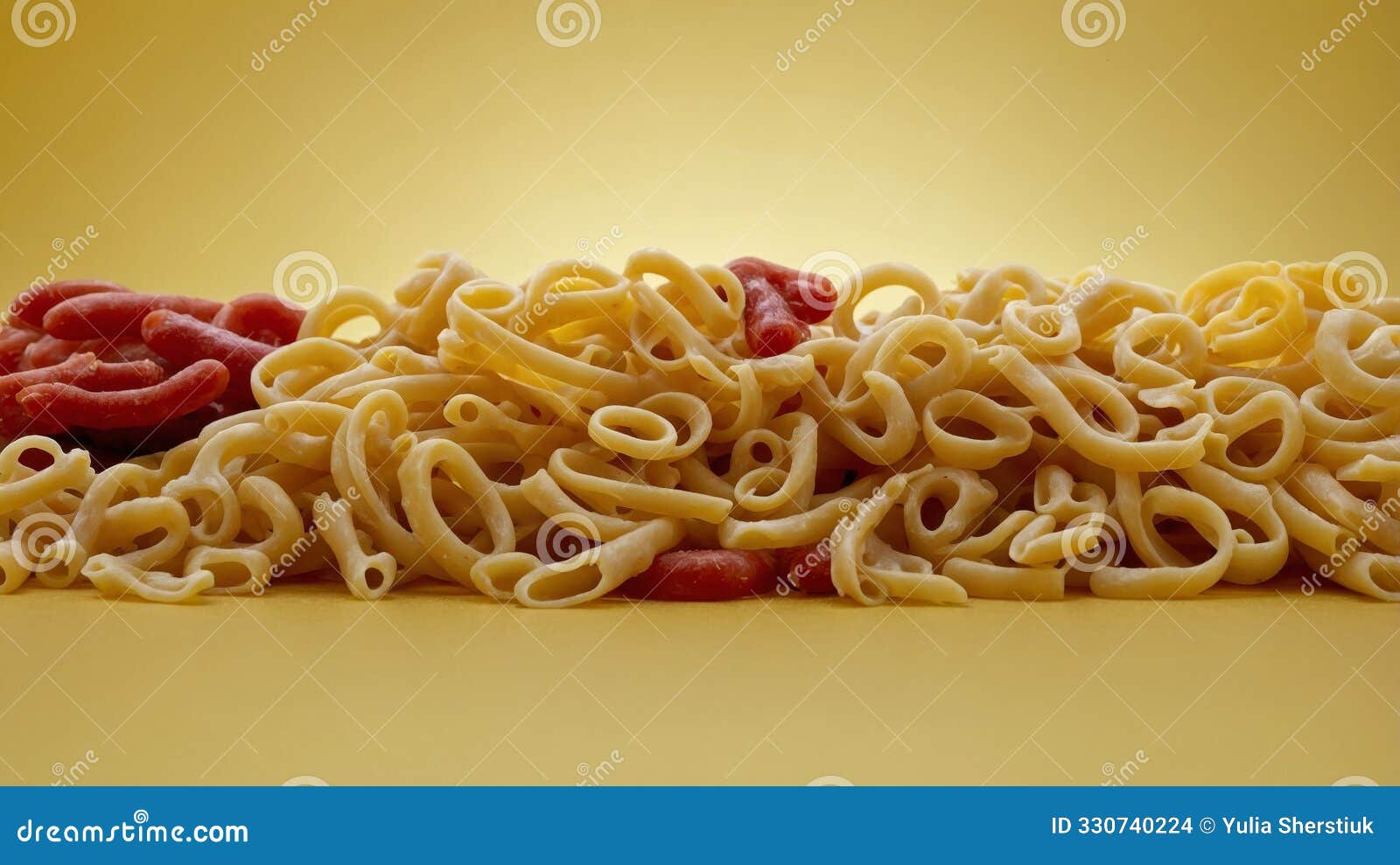 A Creative Layout of Spaghetti and Assorted Pasta Shapes on a Yellow ...