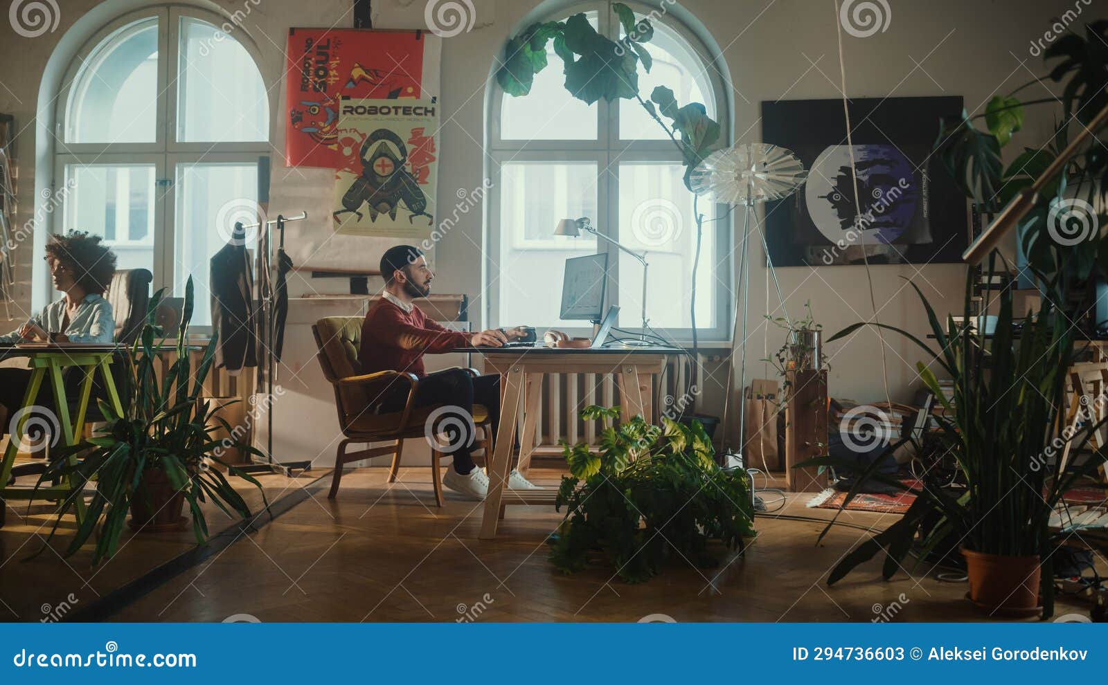 Creative Modern Office: Young Man Sitting at His Desk Working on ...