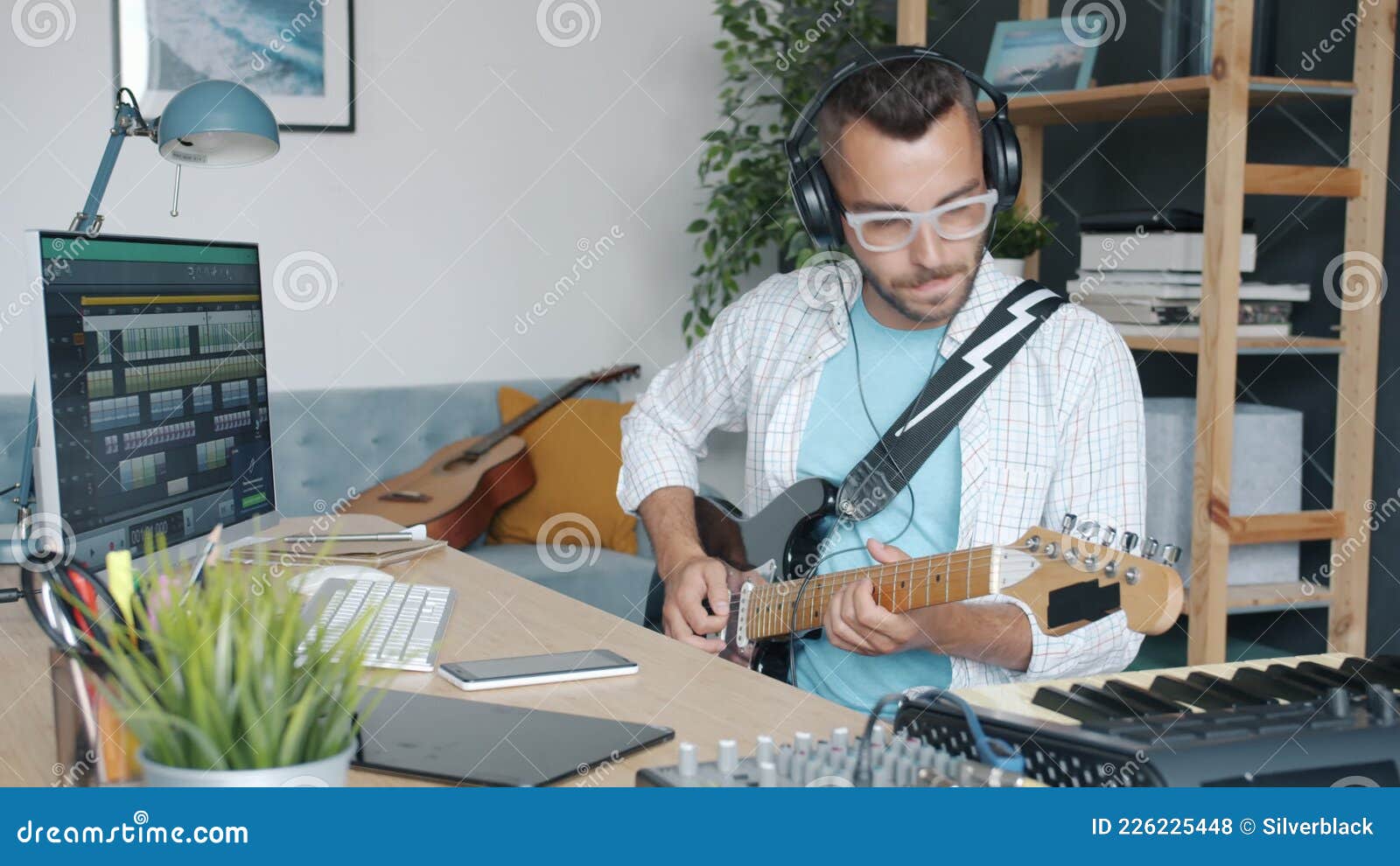 Creative Musician Playing Electric Guitar Wearing Headphones and Using ...