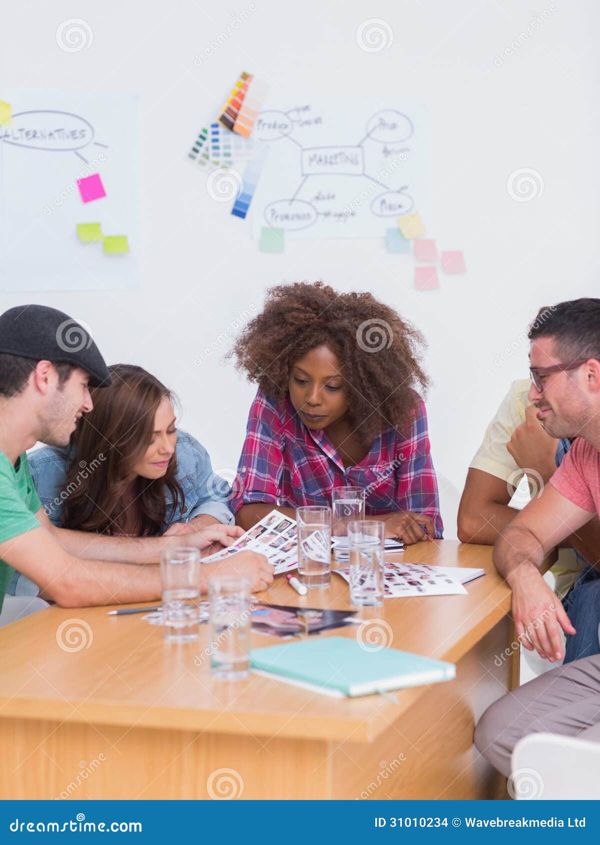 Creative Team Talking Over Contact Sheets in Meeting Stock Photo ...