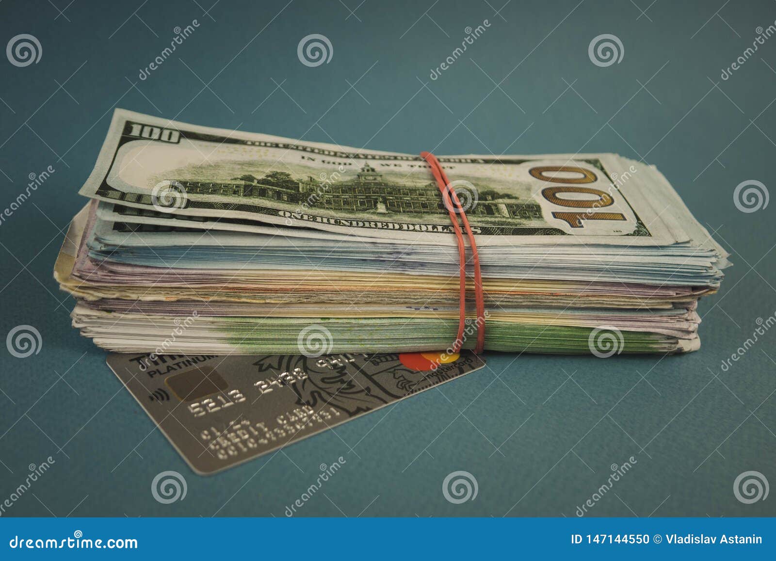 Credit Cards and a Bundle of Money on a Plain Blue Background Editorial ...