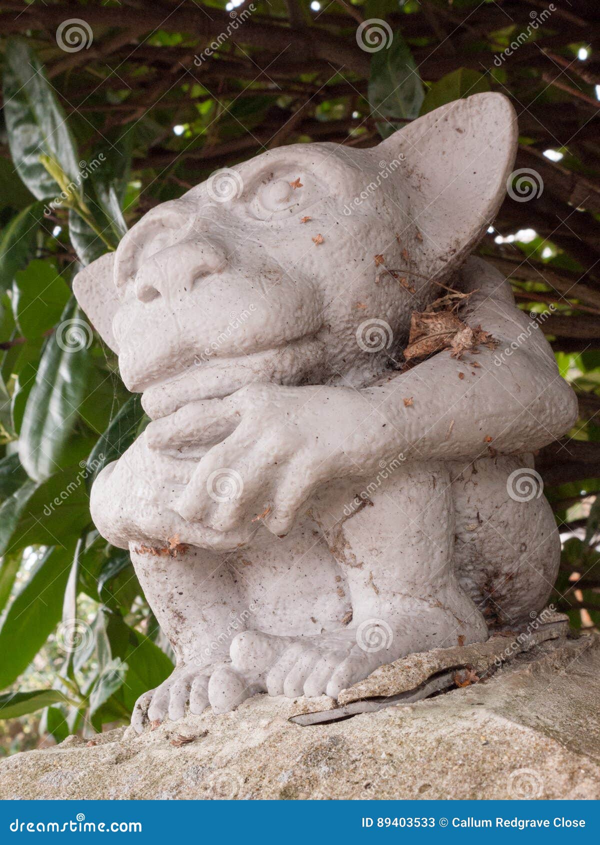 A Creepy Gremlin Statue Sitting Guard on the Wall Stock Image - Image ...