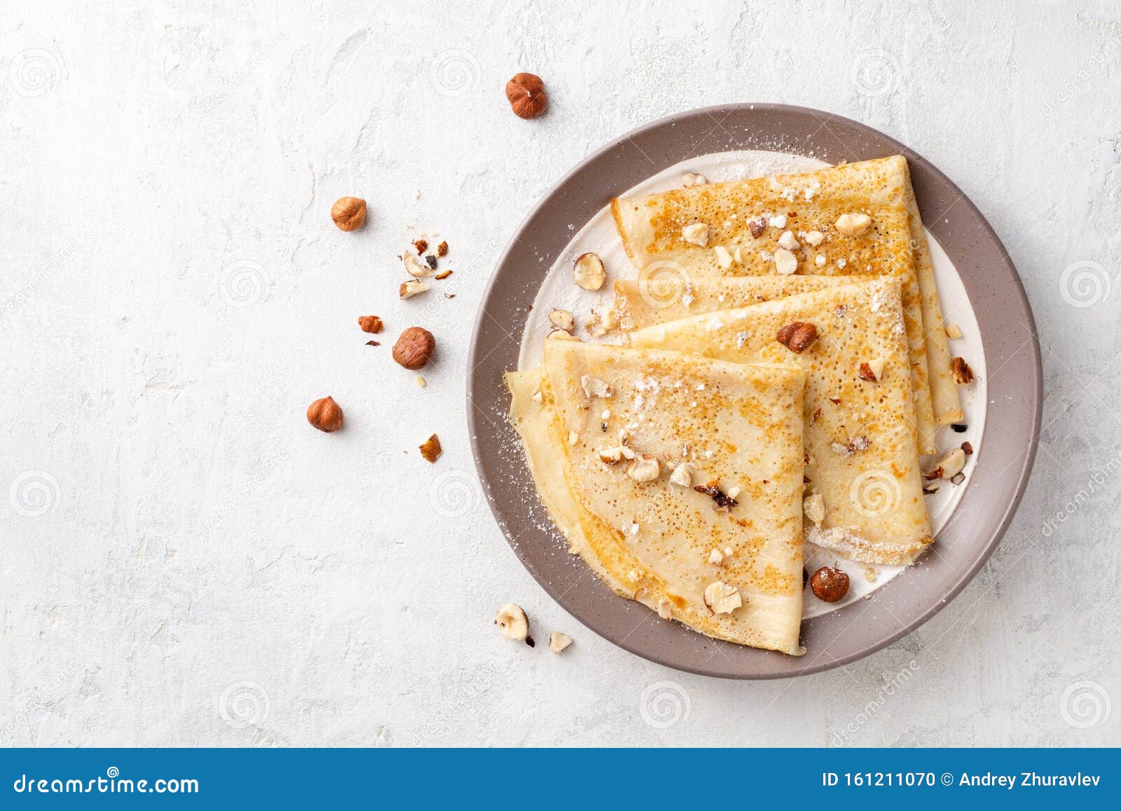 Crepes with Hazelnuts and Powdered Sugar on Plate on White Concrete ...