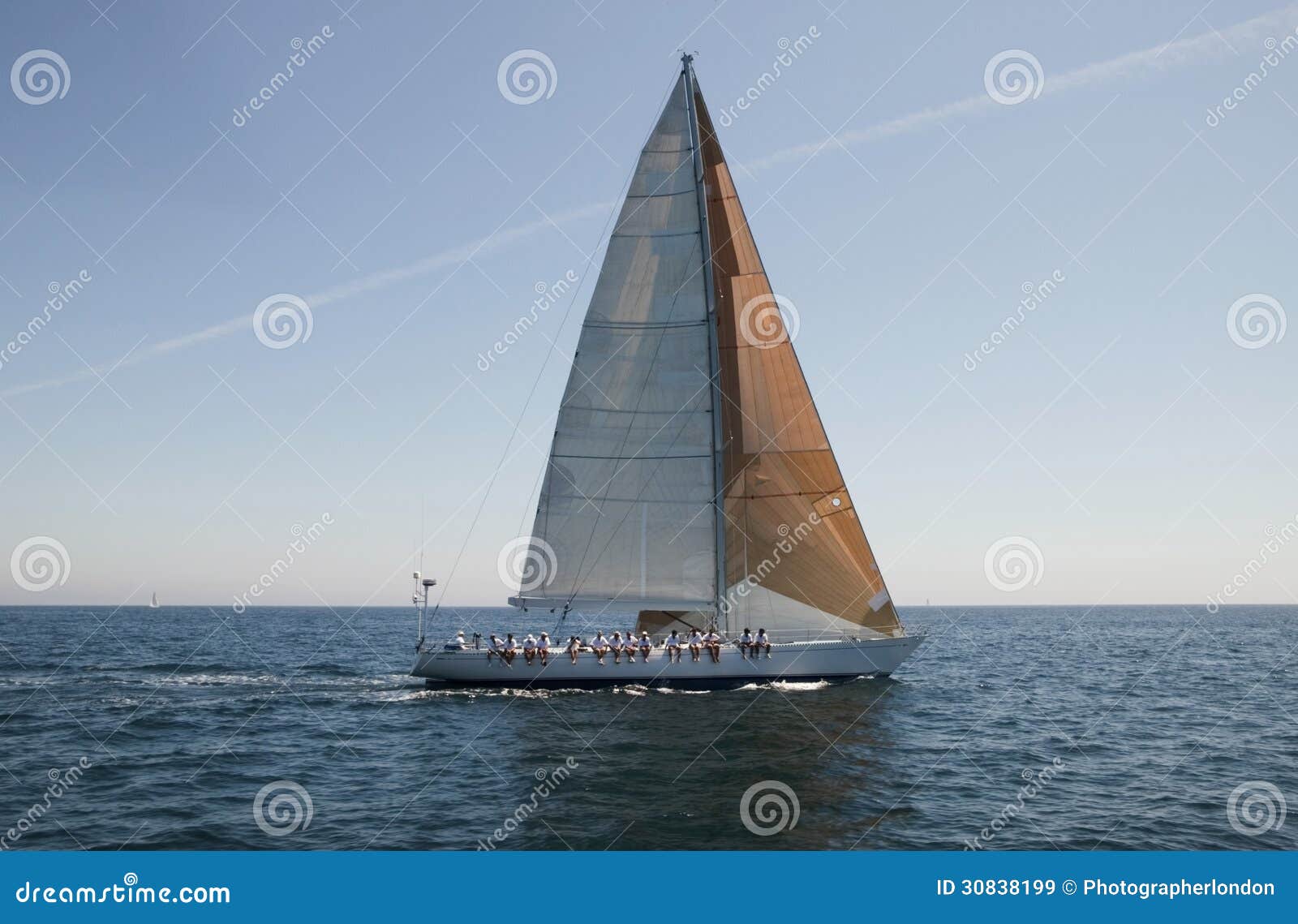 Crew Members Sitting on the Side of a Sailboat in the Ocean Stock Image ...