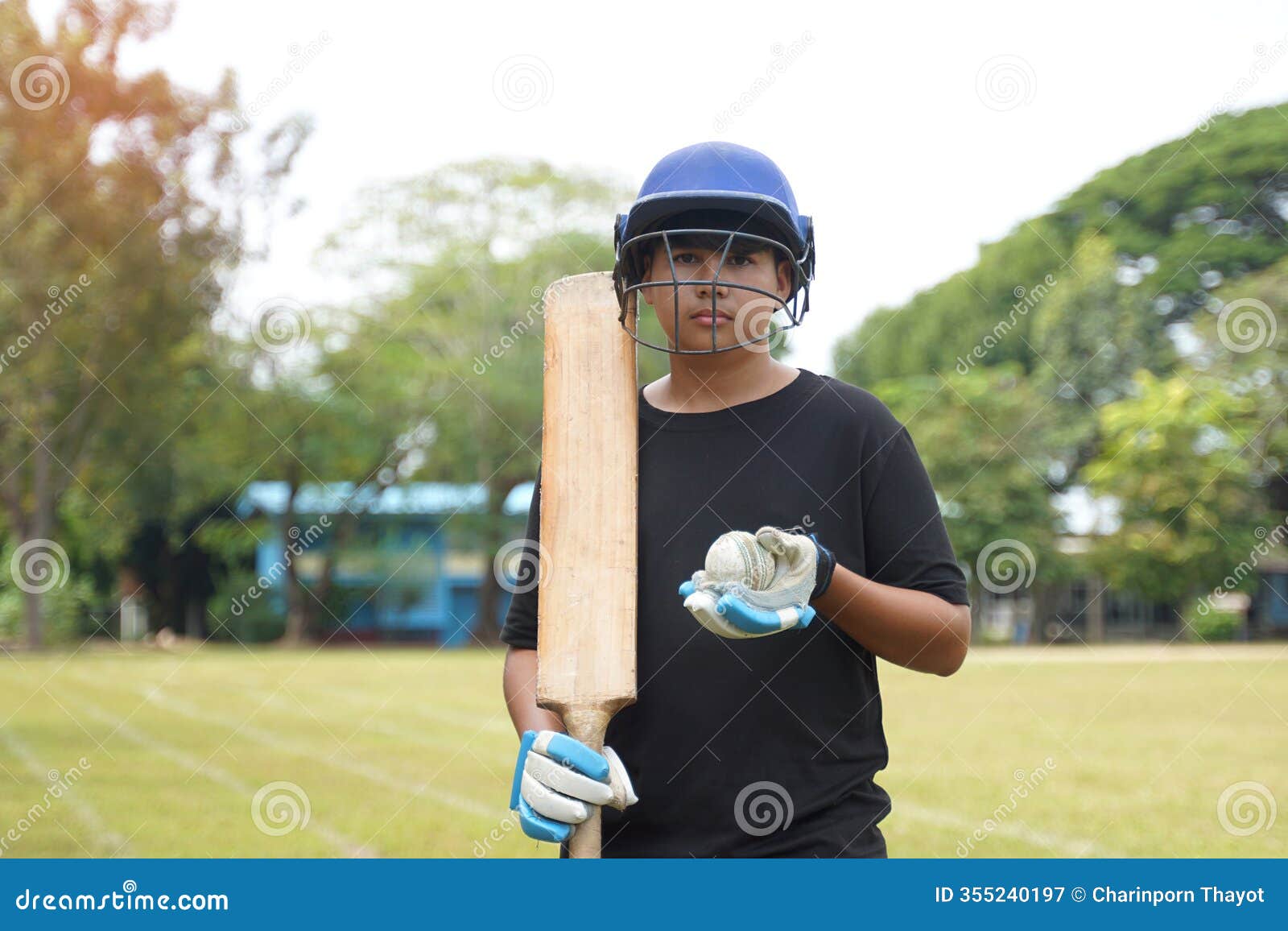 Cricket Player Wearing Cricket Helmet Holds a Bat and Ball in His Hand ...