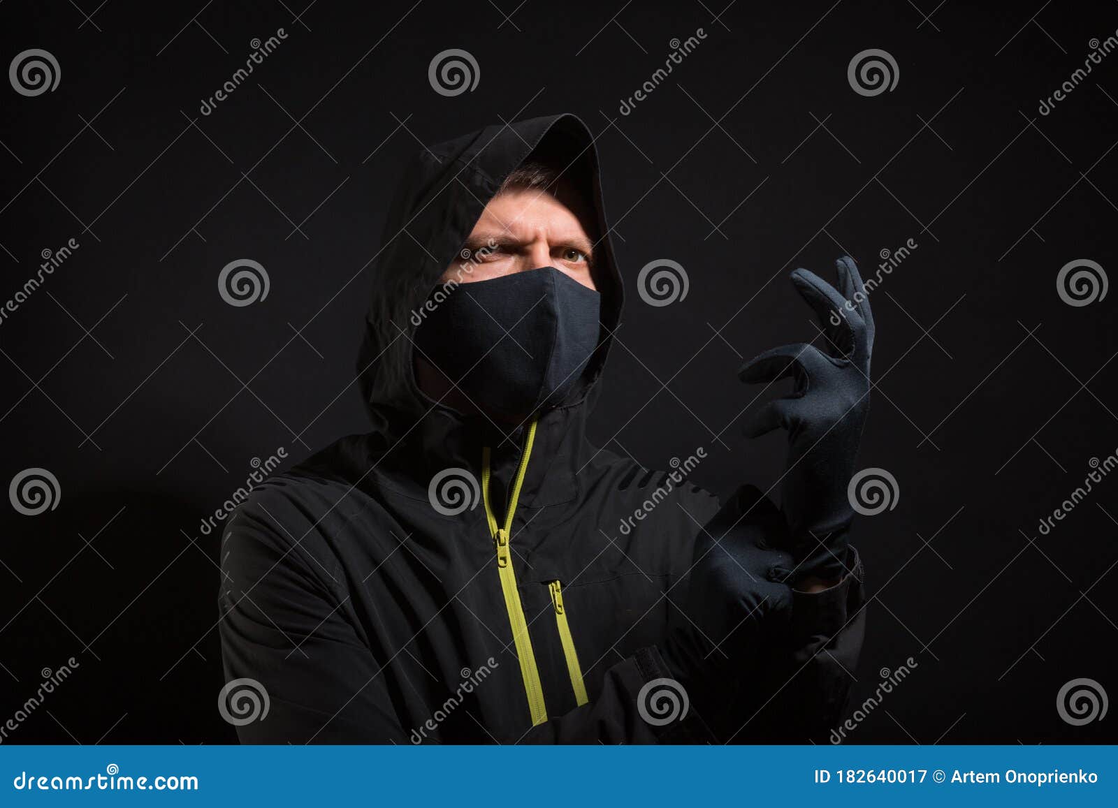 The Criminal in the Mask Puts on a Glove. Preparation for Robbery Stock ...