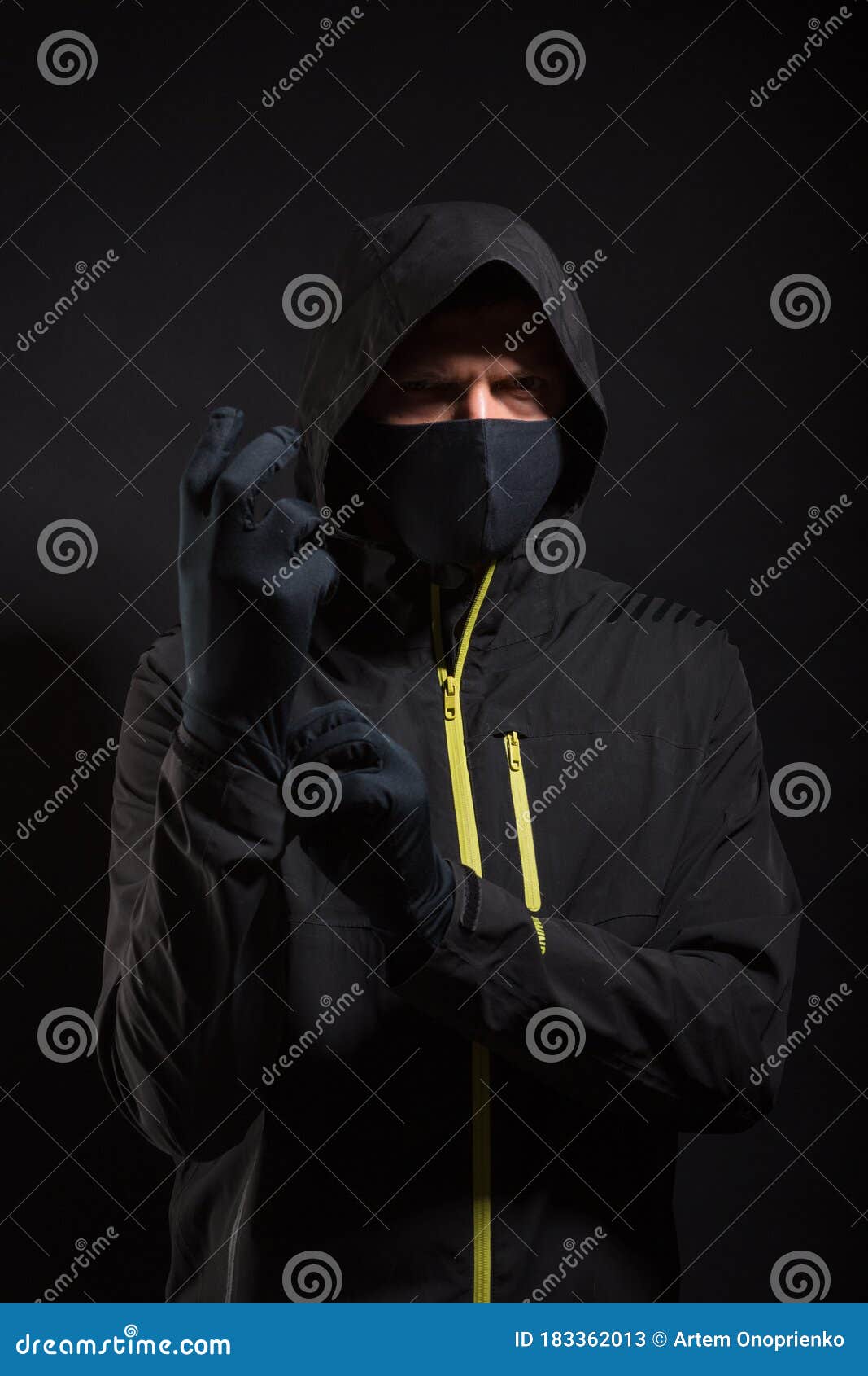The Criminal in the Mask Puts on a Glove. Preparation for Robbery Stock ...