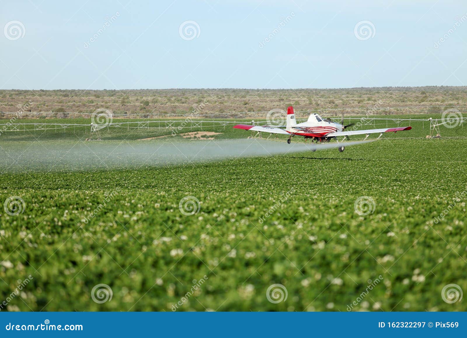 A Crop Dusting Plane Flies Low Over a Farm Field. Stock Image - Image ...