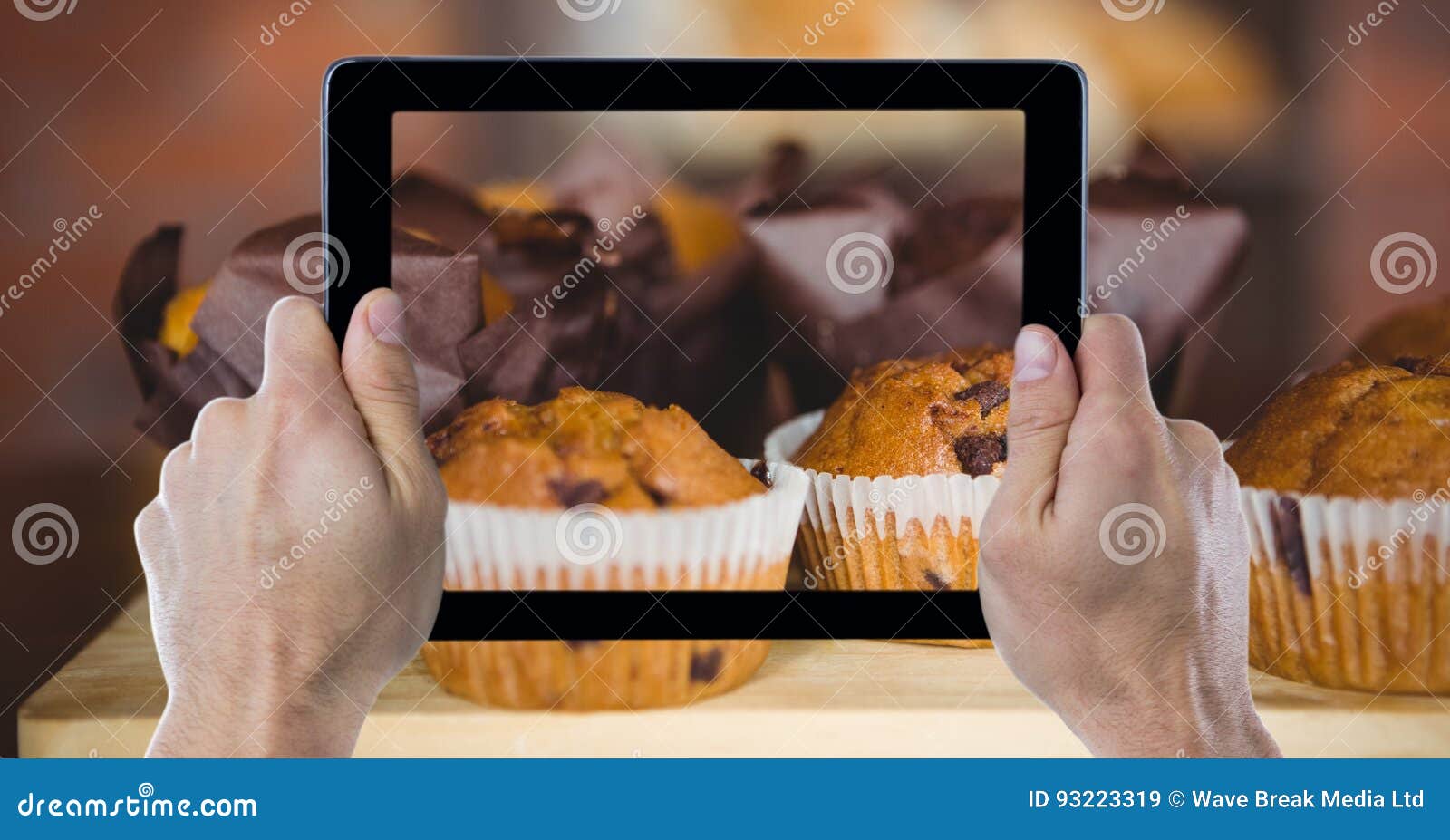 Cropped Hands Photographing Muffins through Digital Tablet at Bakery ...