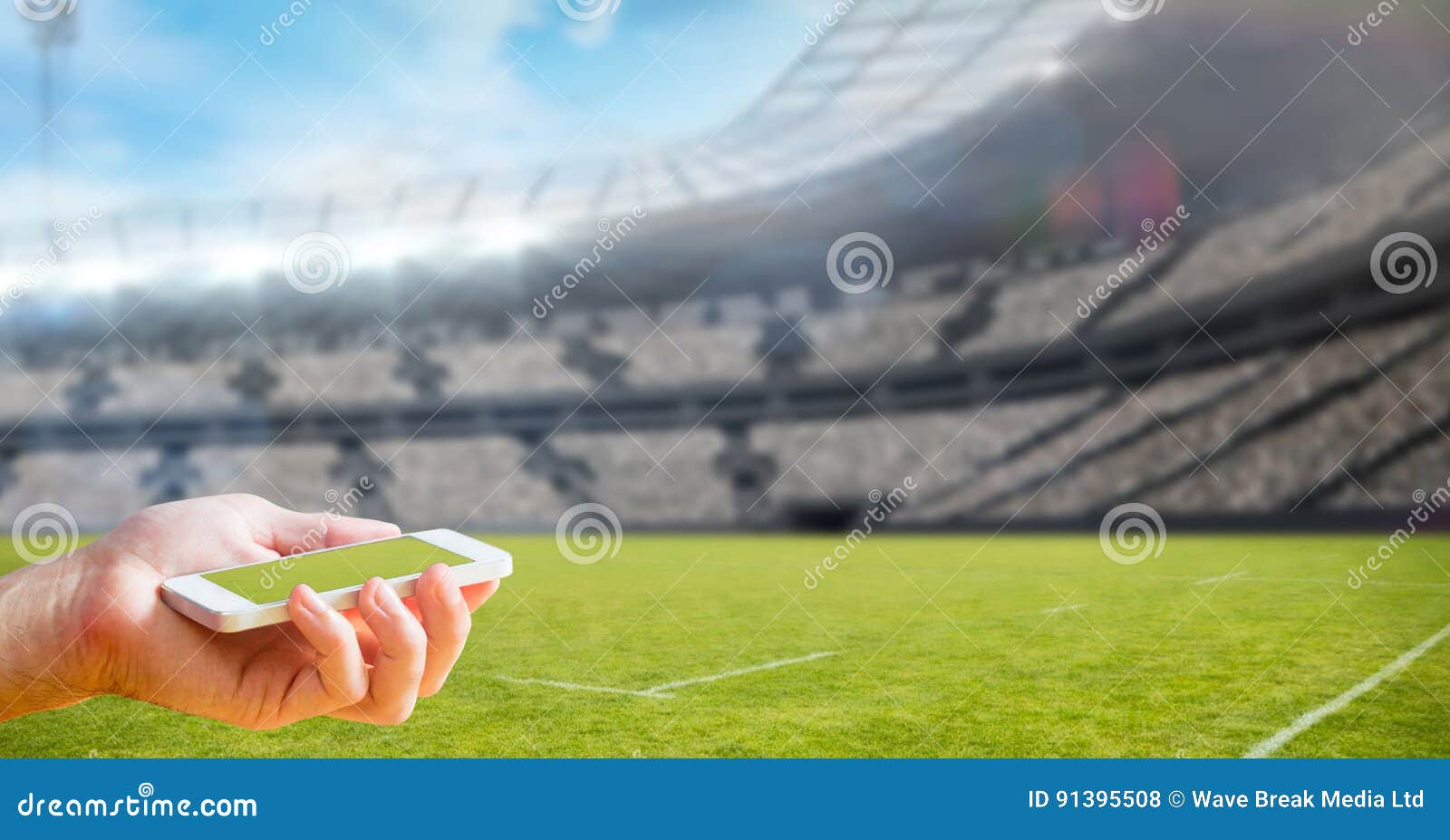 Cropped Image of Hand Holding Smart Phone at Stadium Stock Photo ...