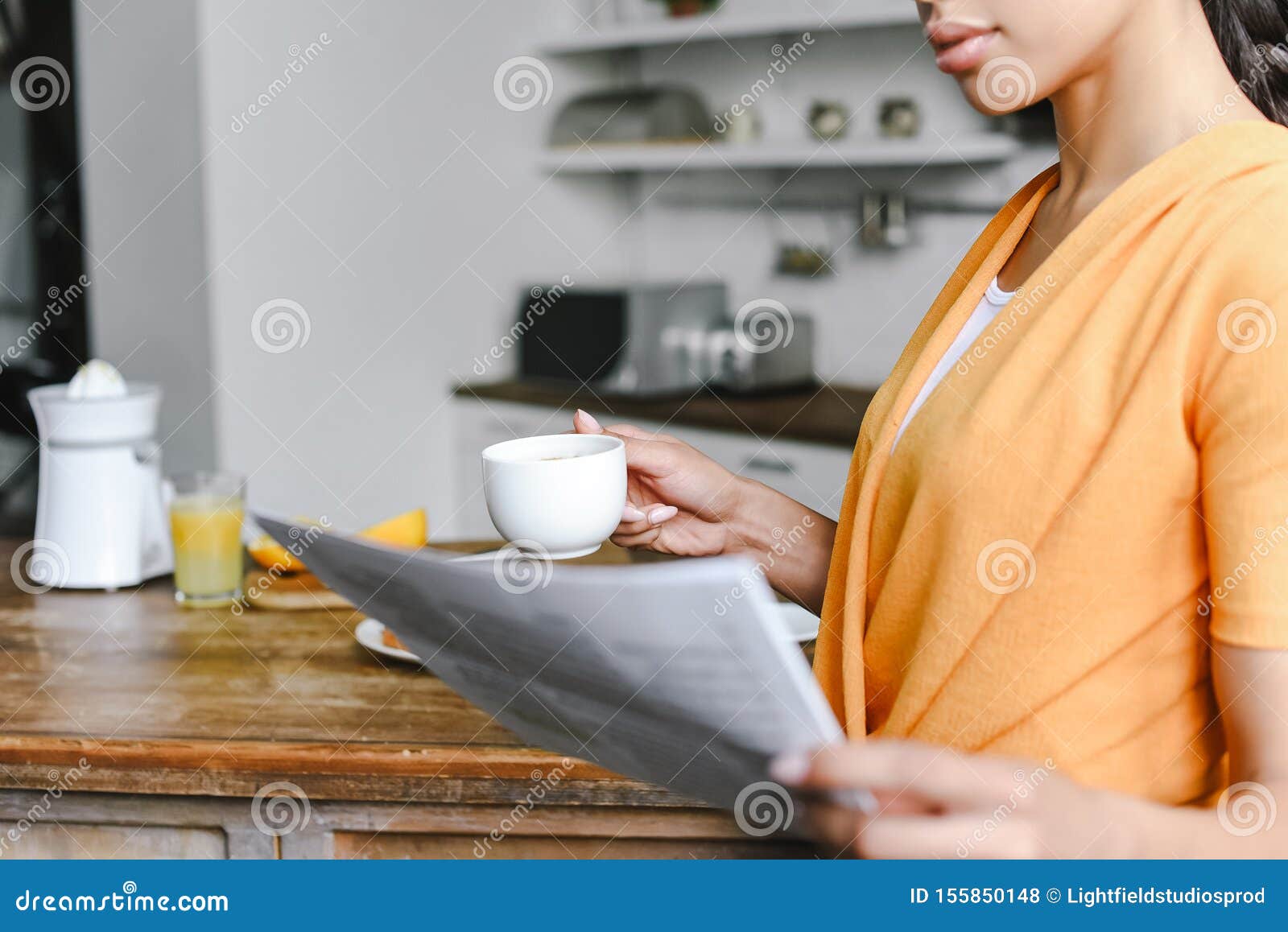 Cropped Image Of Mixed Race Girl In Orange Shirt Holding Cup Of Coffee