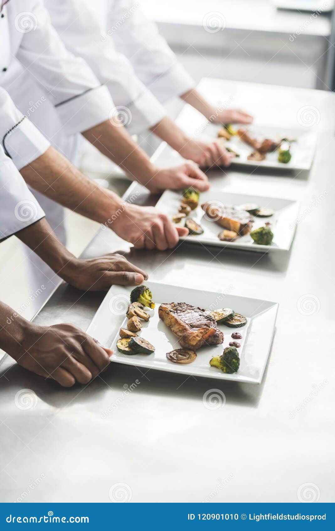 Cropped Image of Multiethnic Chefs with Plates with Steaks Stock Photo ...
