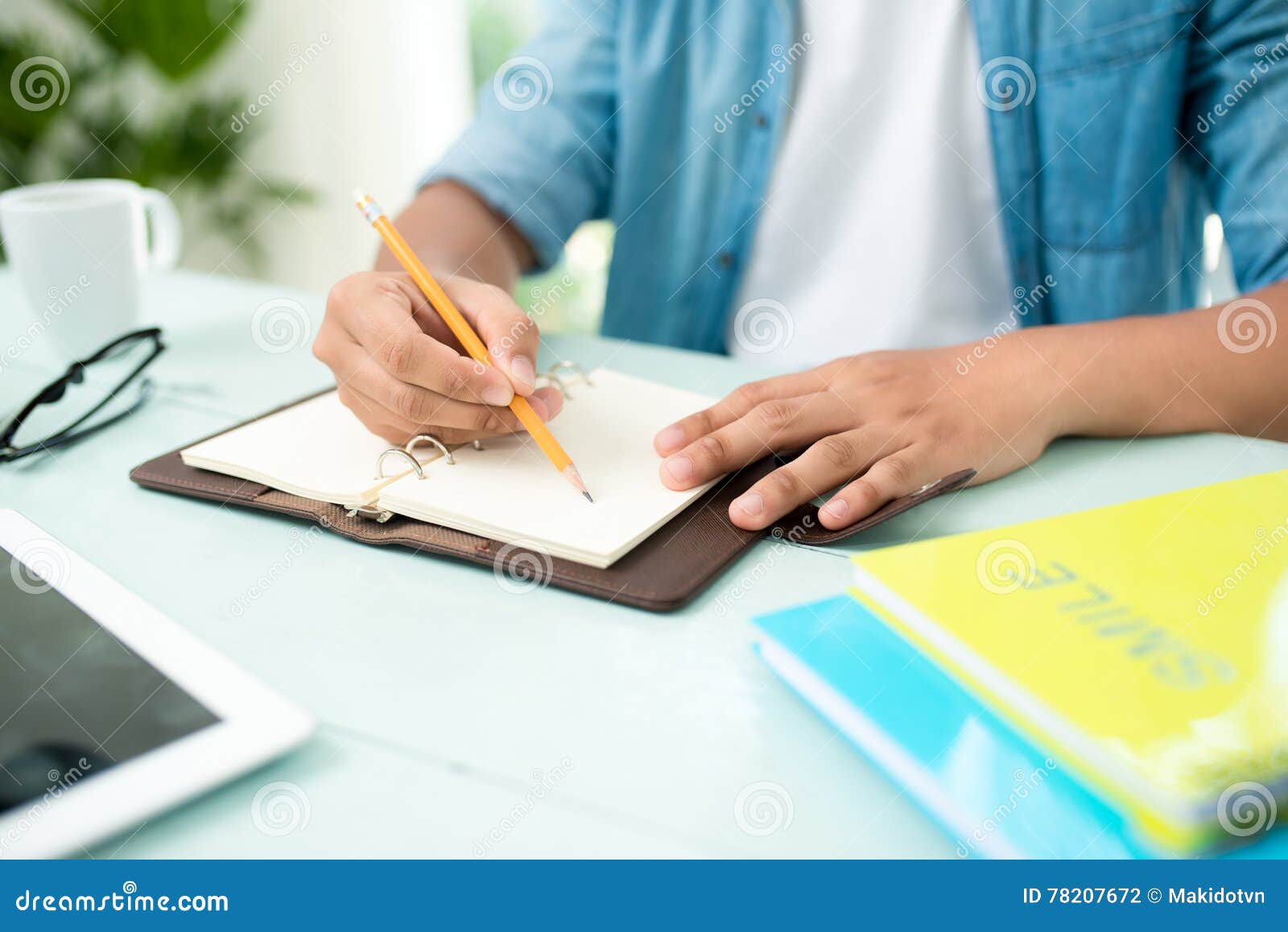 Cropped Image of Young Man Writing Something on Notebook at Office Desk ...