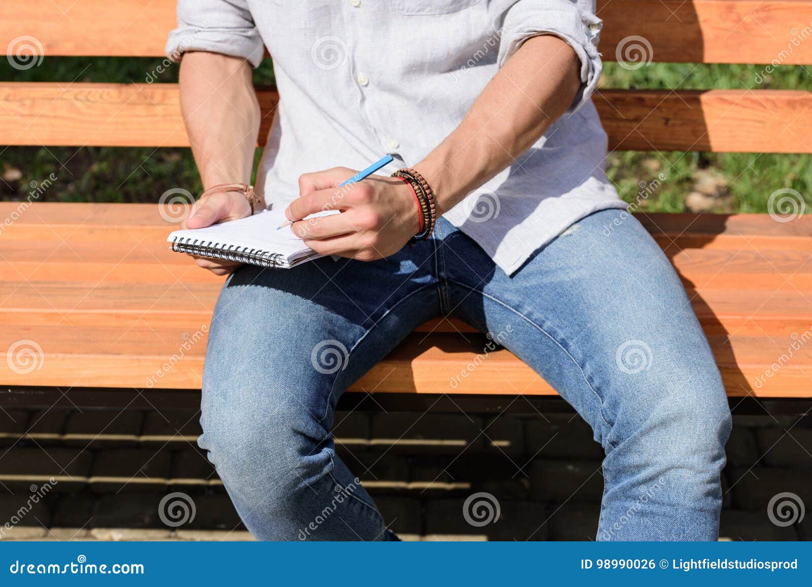 Student Writing in Notebook while Sitting on Bench in Park Stock Photo ...
