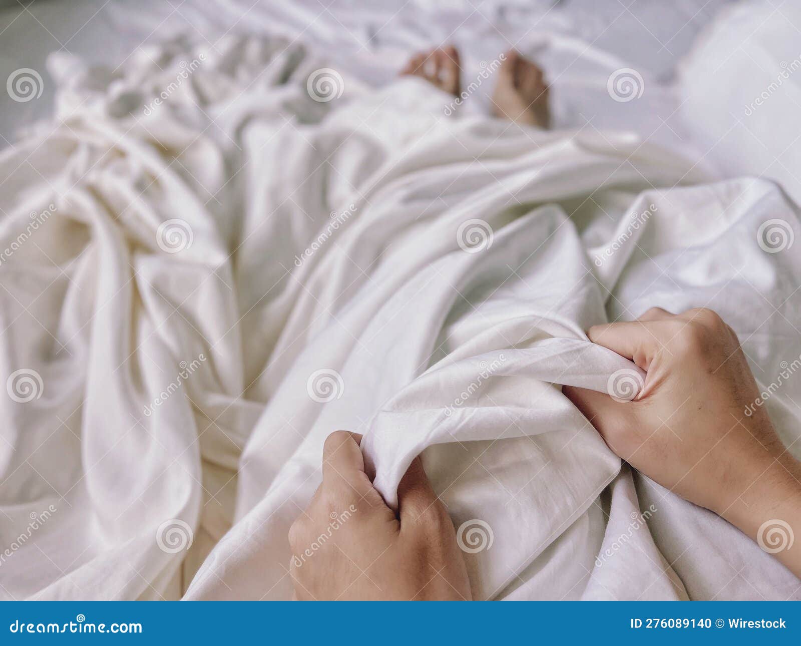 Cropped View of Two Hands Holding on a Rumpled Bedspread Stock Photo ...