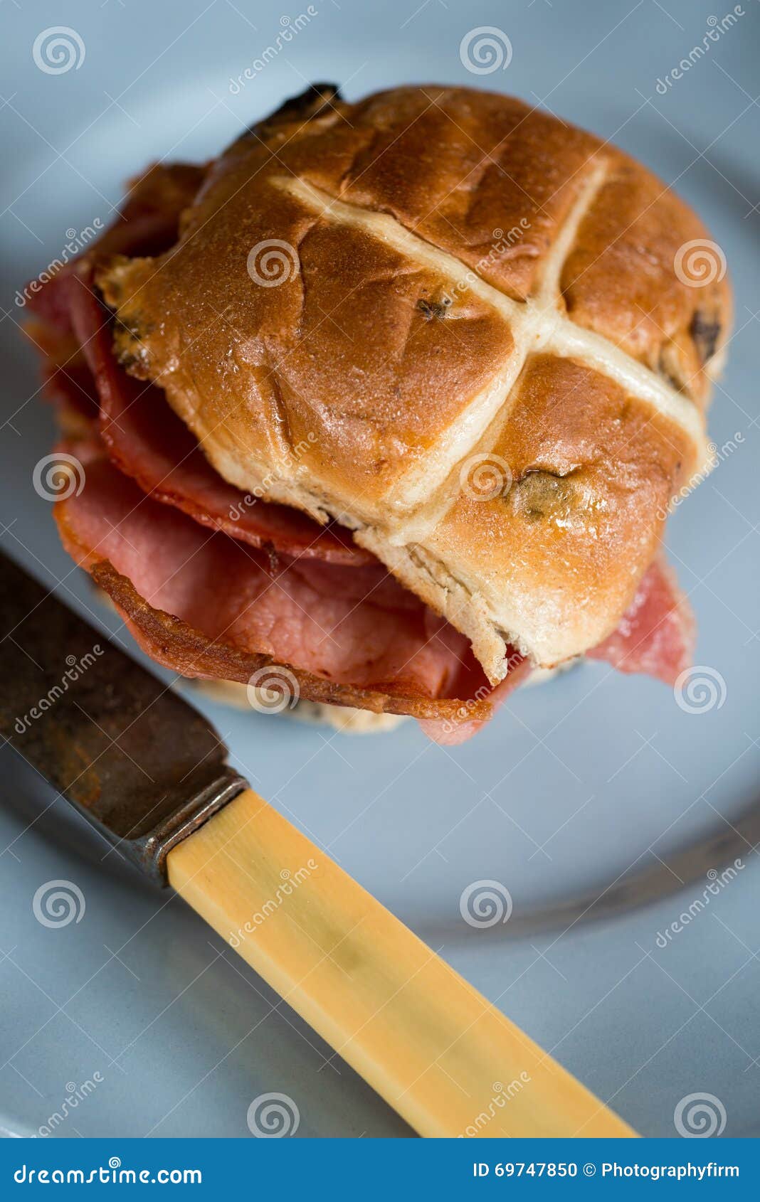 Cross Bun and Rusty Dinner Knife on White Round Plate Stock Photo ...