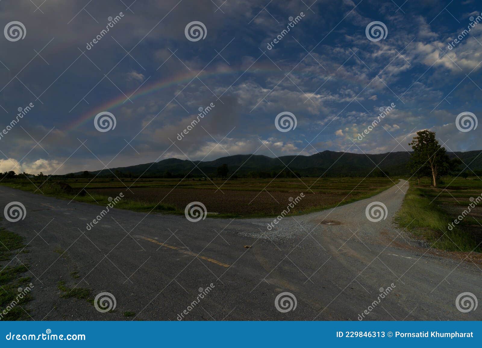 Crossroads in a Rural Road on the Background of the Sky and Rainbow ...