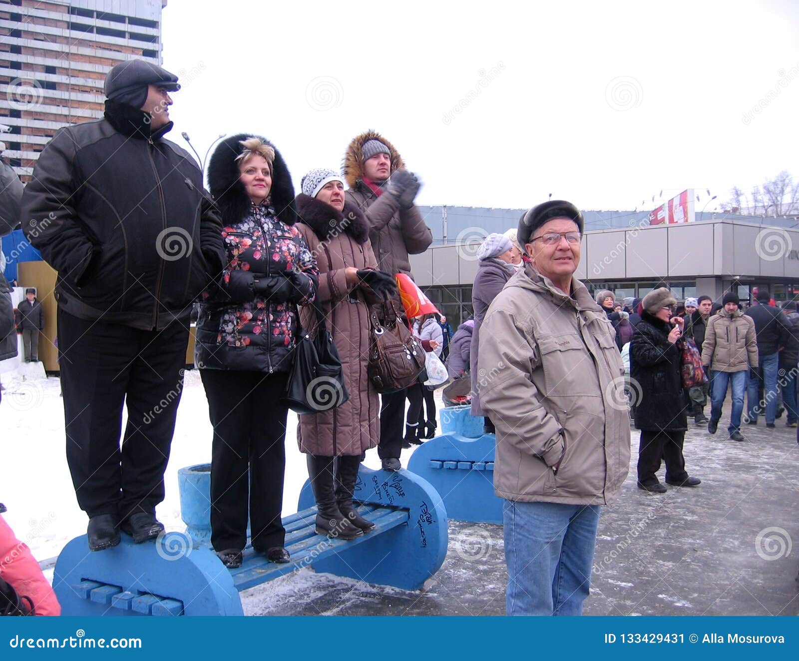 A Crowd of People in the Winter Standing on a Bench Waiting for the ...