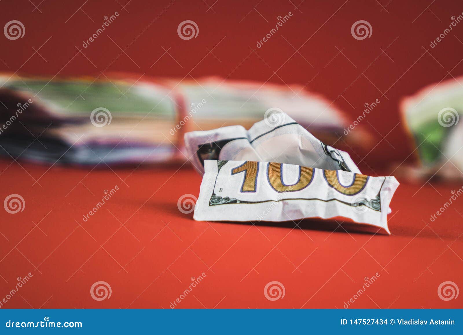 Crumpled Bill Lying in the Foreground and Behind a Bundle of Cash on a ...