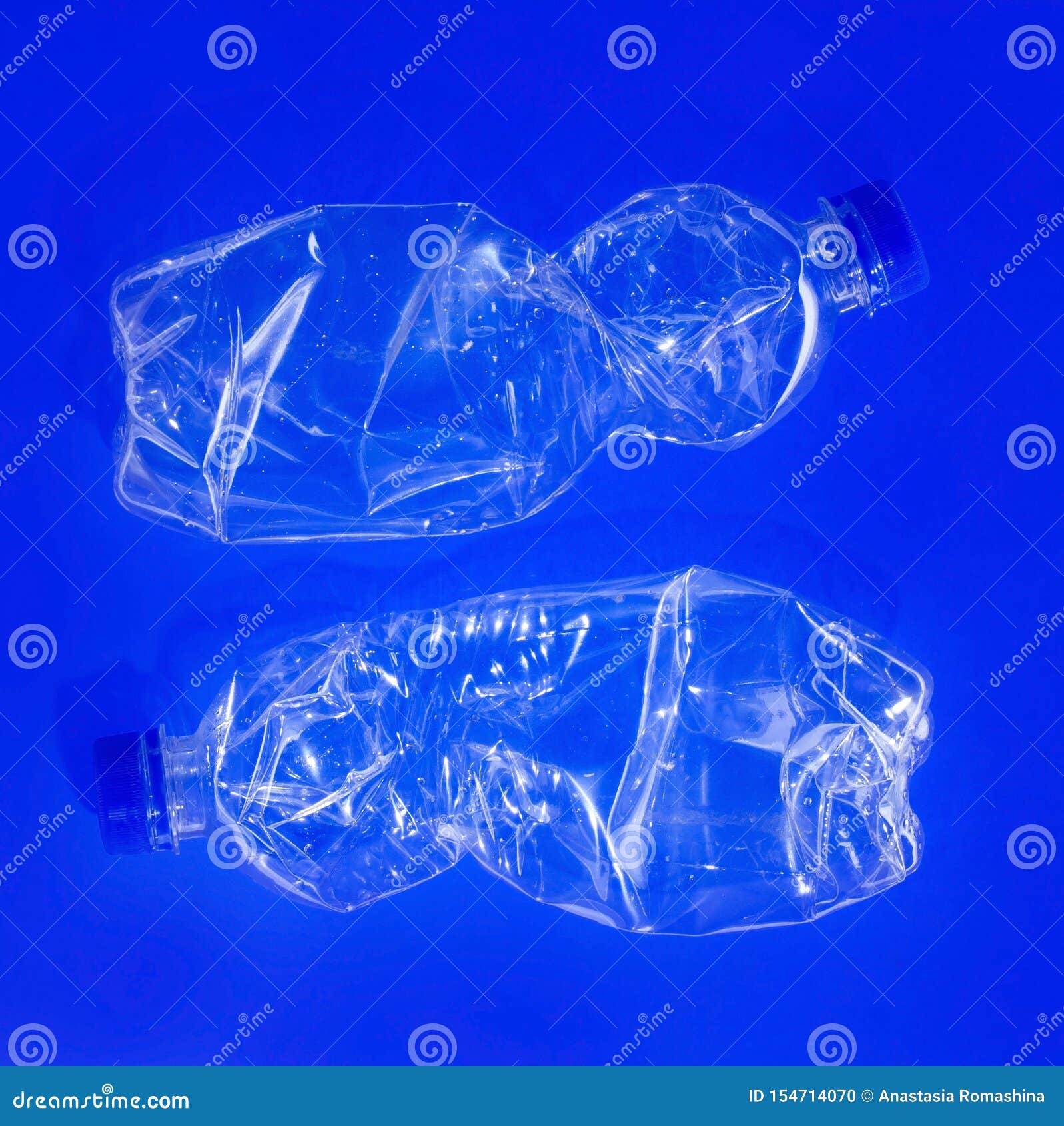 Crumpled Plastic Bottle on a Blue Background. Plastic Trash Stock Photo ...