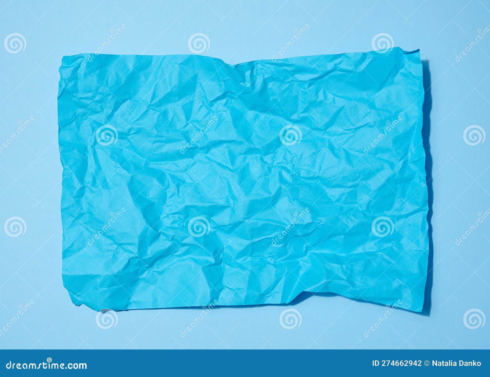 Crumpled Rectangular Sheet of Blue Paper on a Blue Background, Top View ...
