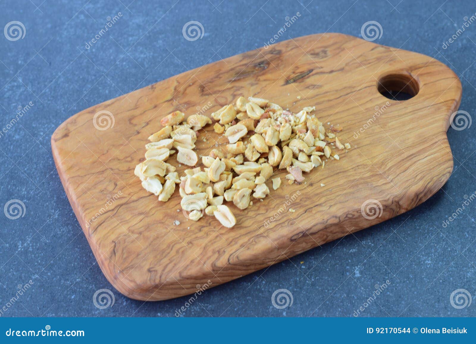 Crushed Peanuts on a Olive Wood Cutting Board on a Blue Abstract ...