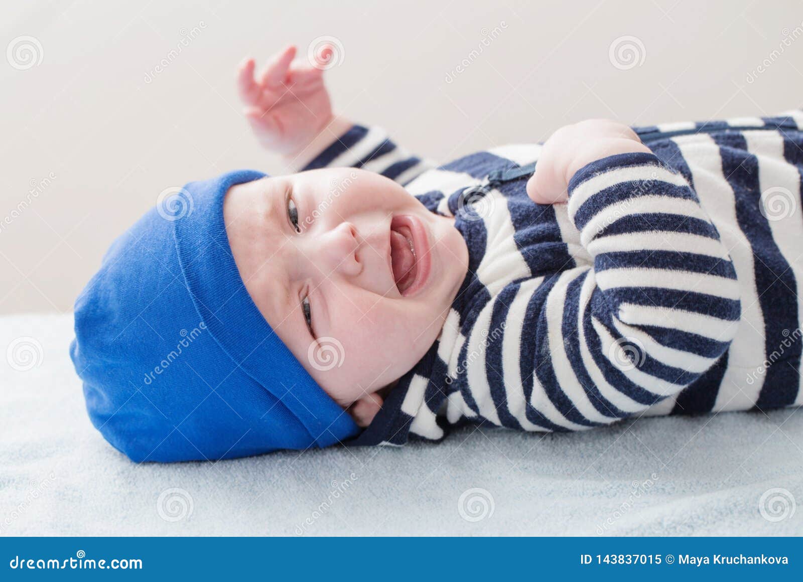 Crying baby in blue hat stock image. Image of childhood - 143837015