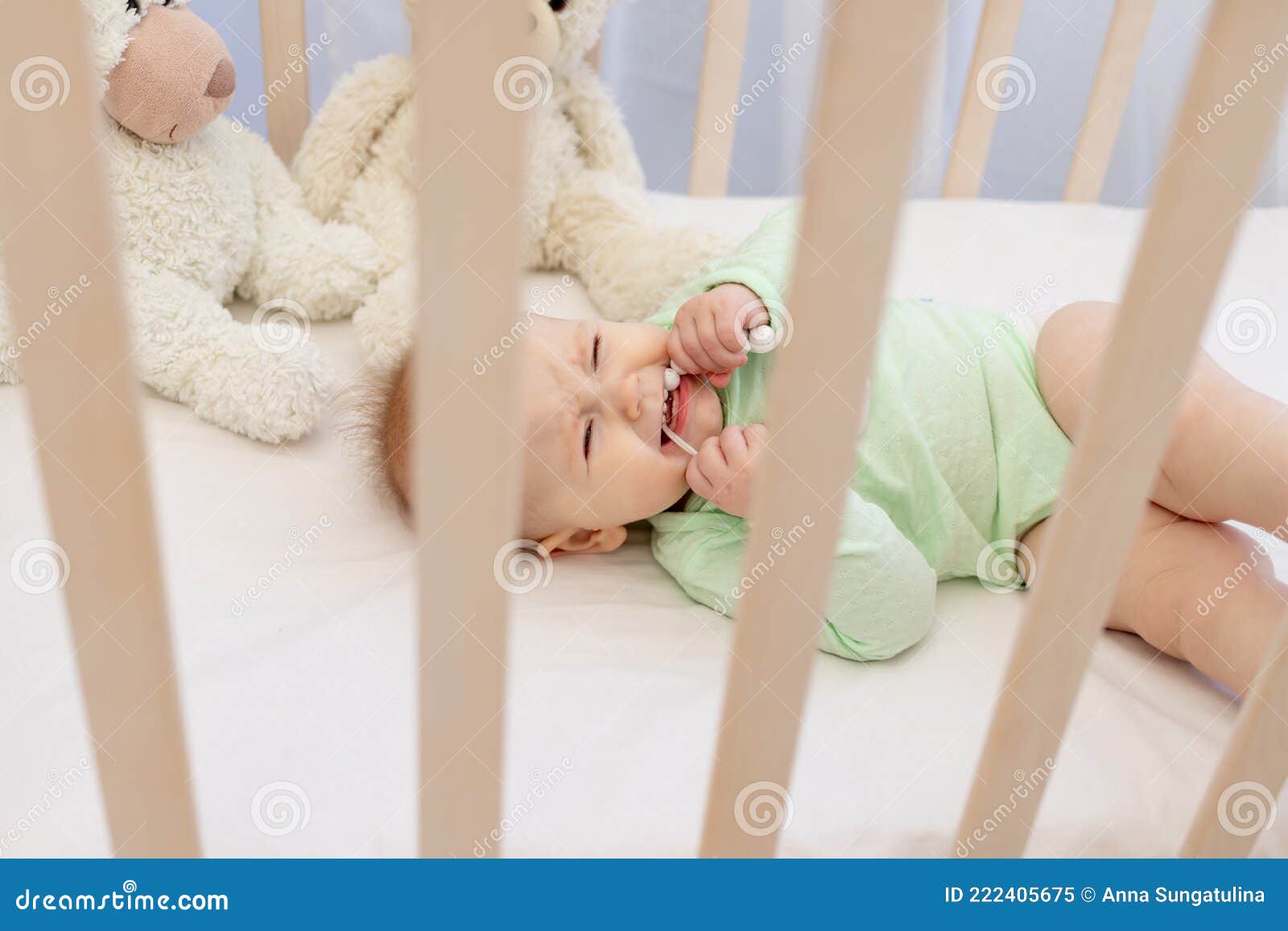 A Crying Baby in a Crib with a Teether in the Bedroom Stock Image ...