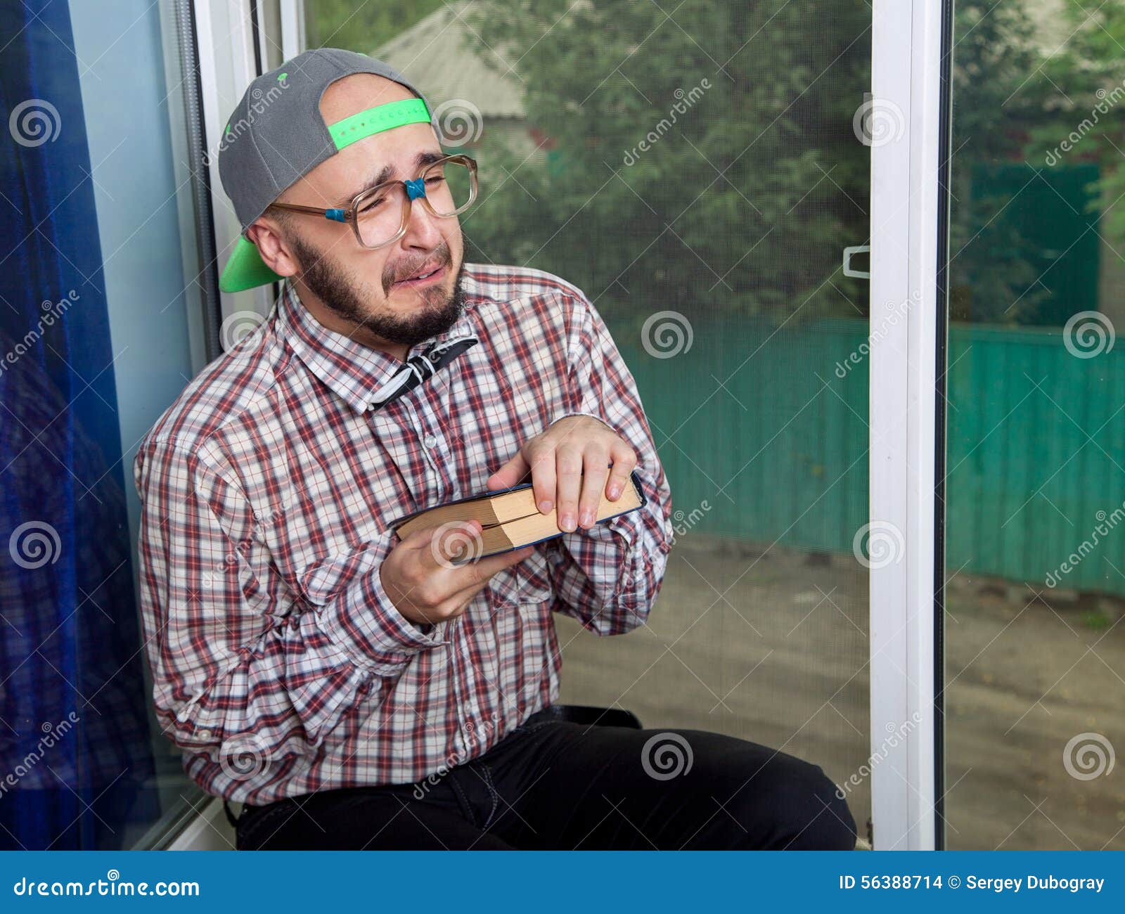 Crying nerd reading a book stock photo. Image of grimacing - 56388714