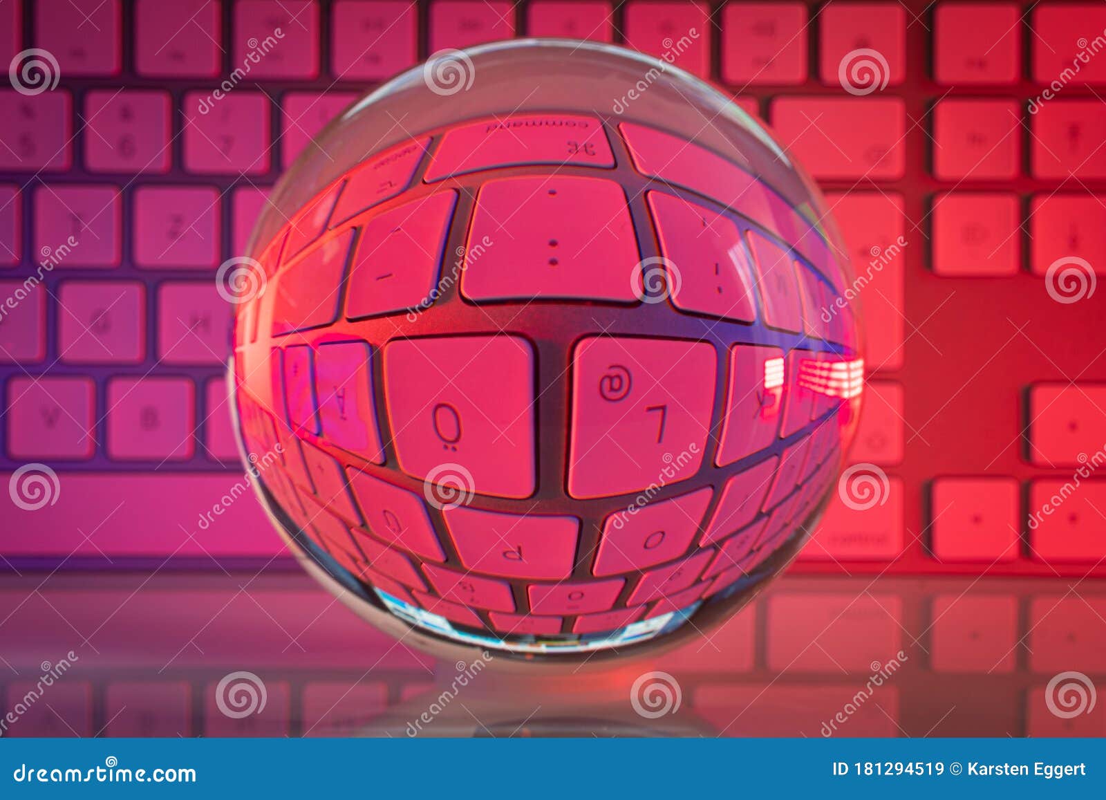 Crystal-clear Glass Ball Stands in Front of a White Computer Keyboard ...