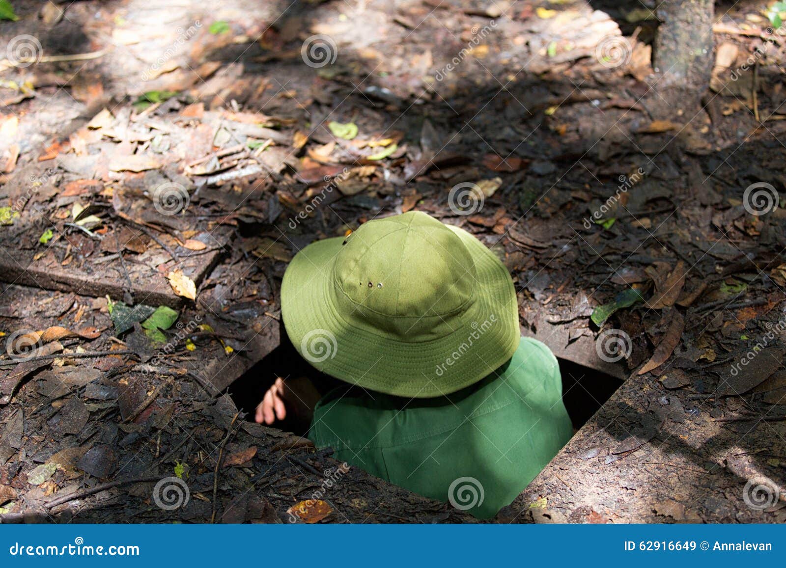 CU CHI, VIETNAM - April 17, 2015: A Guide Demonstrating How A Vietcong ... CU CHI, VIETNAM - April 17, 2015: A Guide Demonstrating How A Vietcong ...