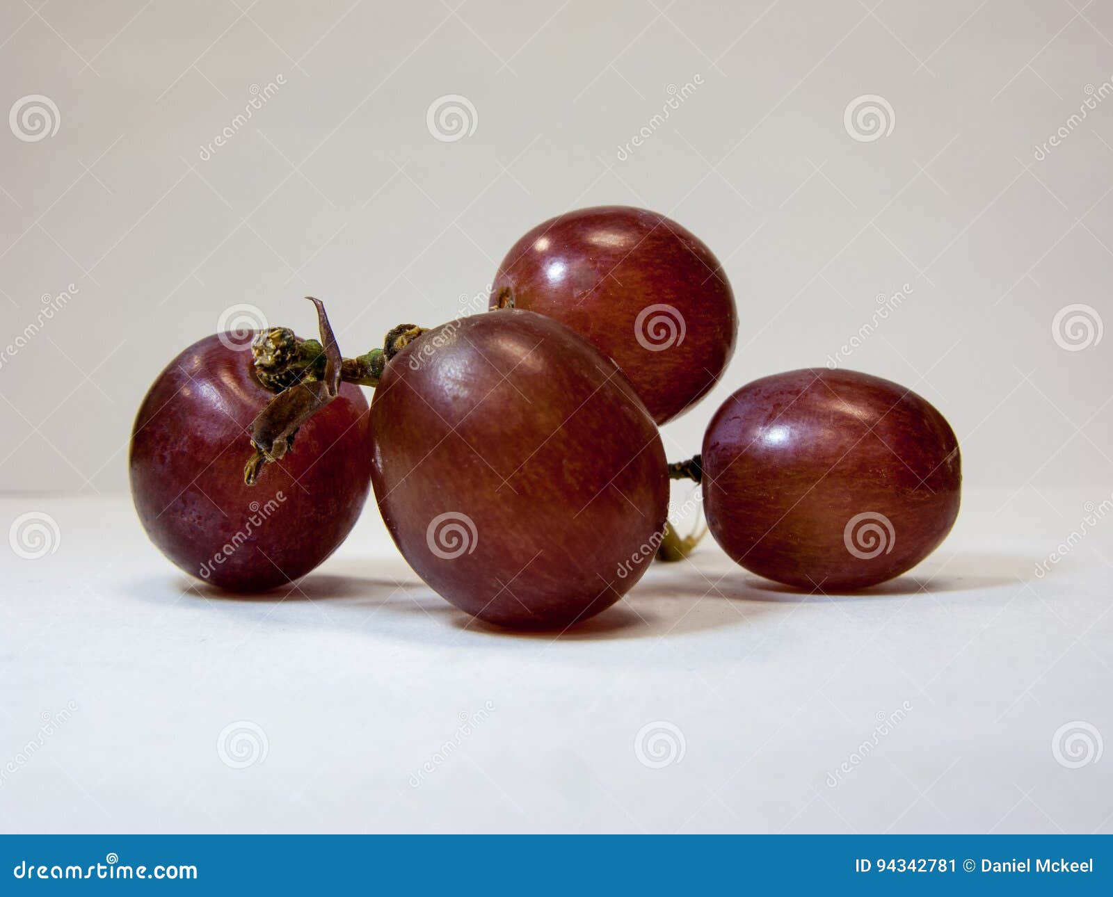 Cuatro uvas en blanco imagen de archivo. Imagen de crudo - 94342781