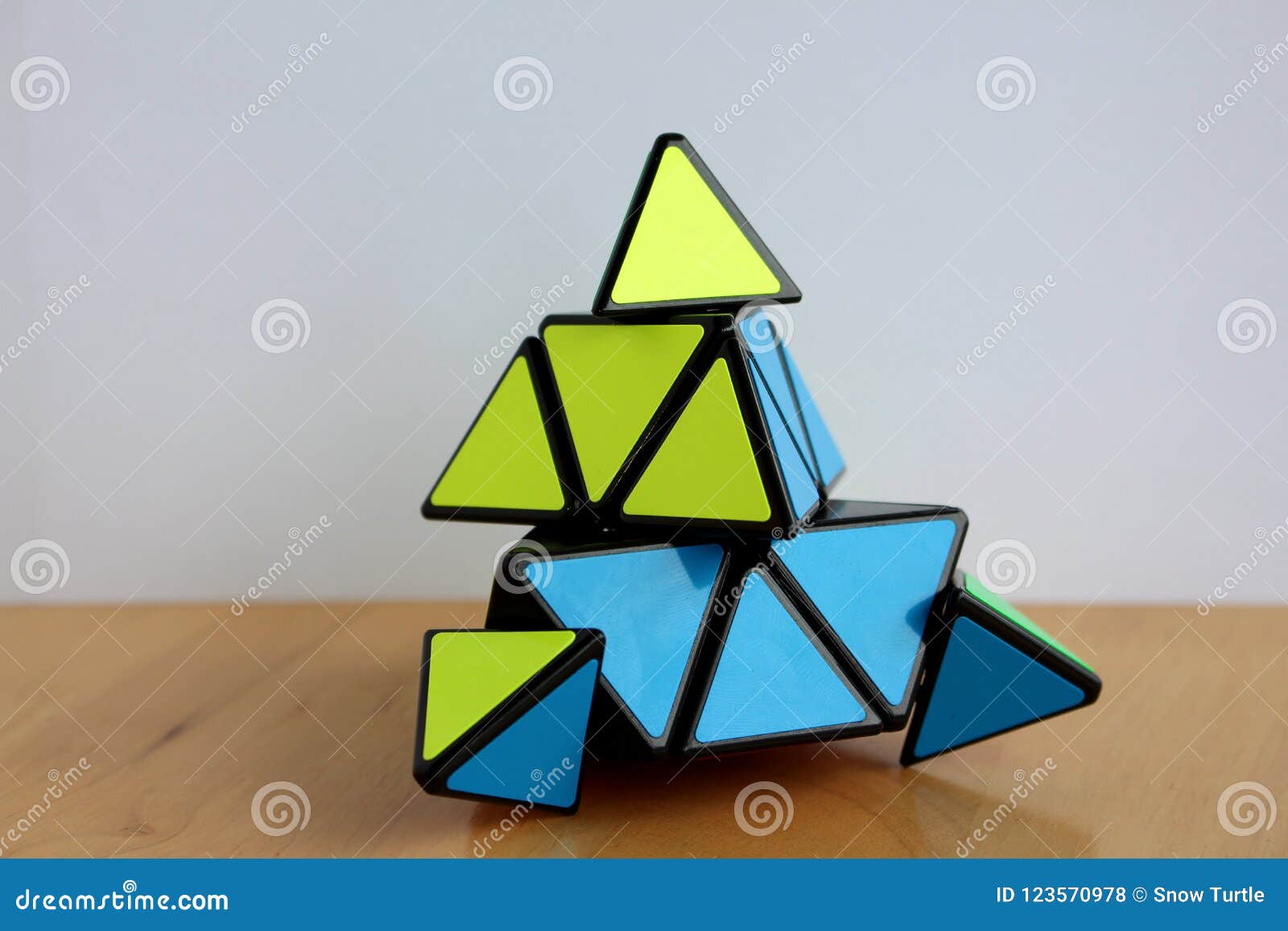 Cubo Del ` S Pyraminx De Rubik En Una Tabla Foto de archivo editorial ...