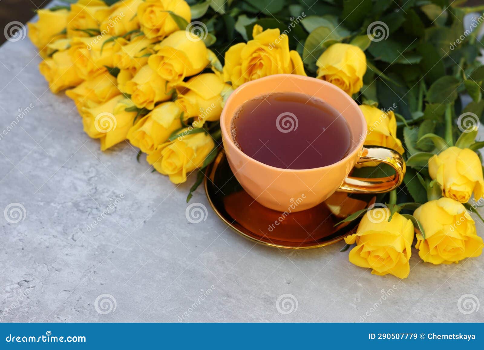 Cup of Tea and Beautiful Yellow Roses on Light Table, Space for Text ...