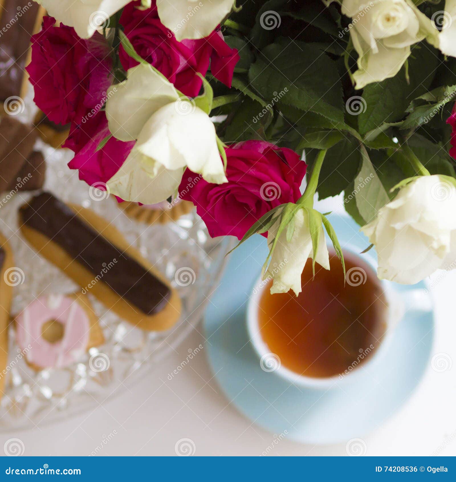 Cup of tea and eclairs stock photo. Image of cookies - 74208536