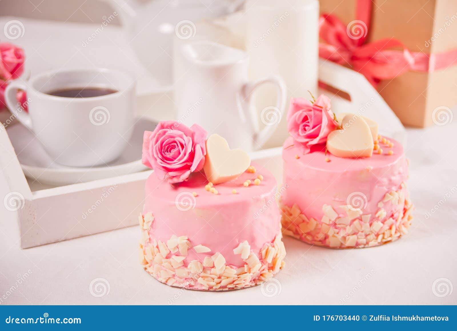 A Cup of Tea, Pink Roses, Gift Box and Small Cakes on the White Table ...