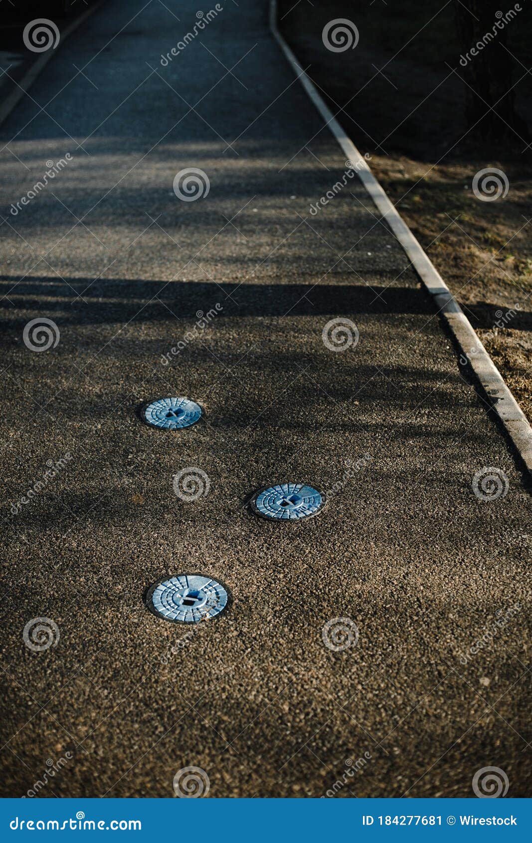 Curb Box Covers on a Concrete Path Stock Image - Image of metal, water ...