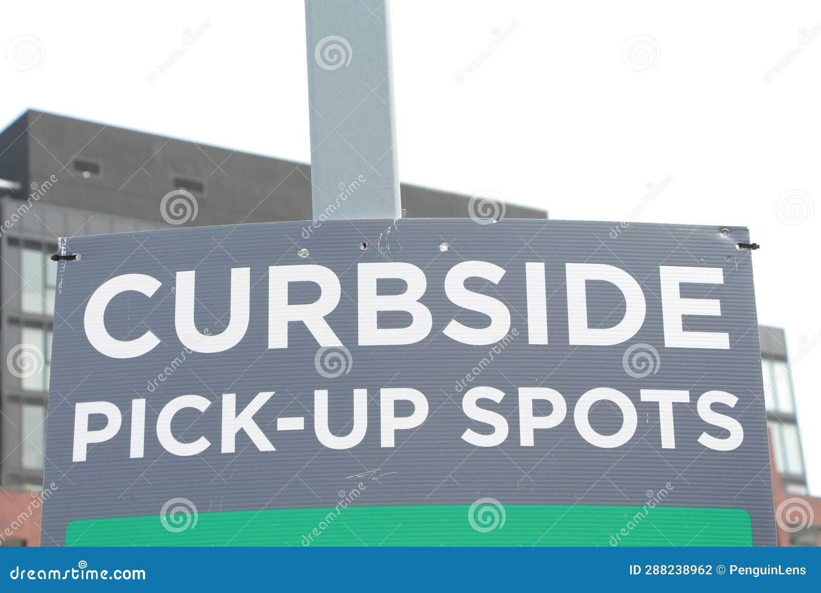 Curbside Pick Up Spots Sign on Post with Building and Sky in Background ...