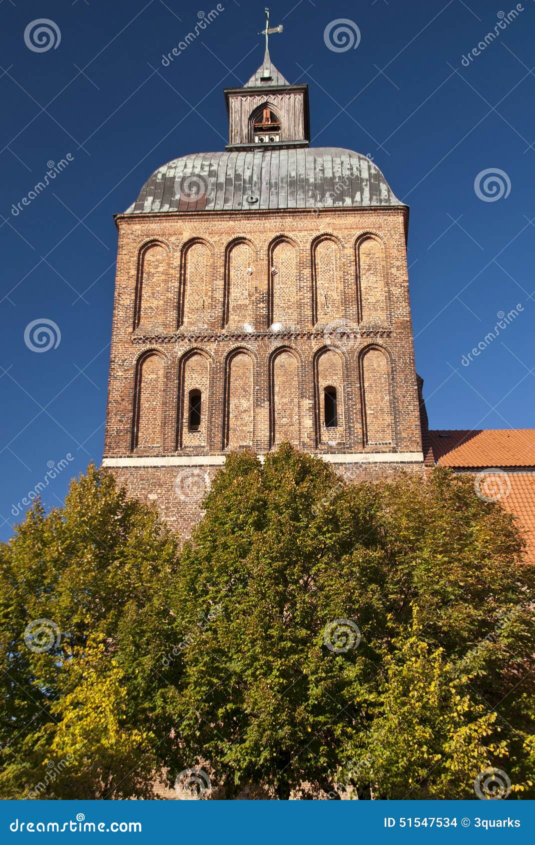 Marienkirche Ribnitz Surrounded By Trees Under A Blue Sky And Sunlight ...