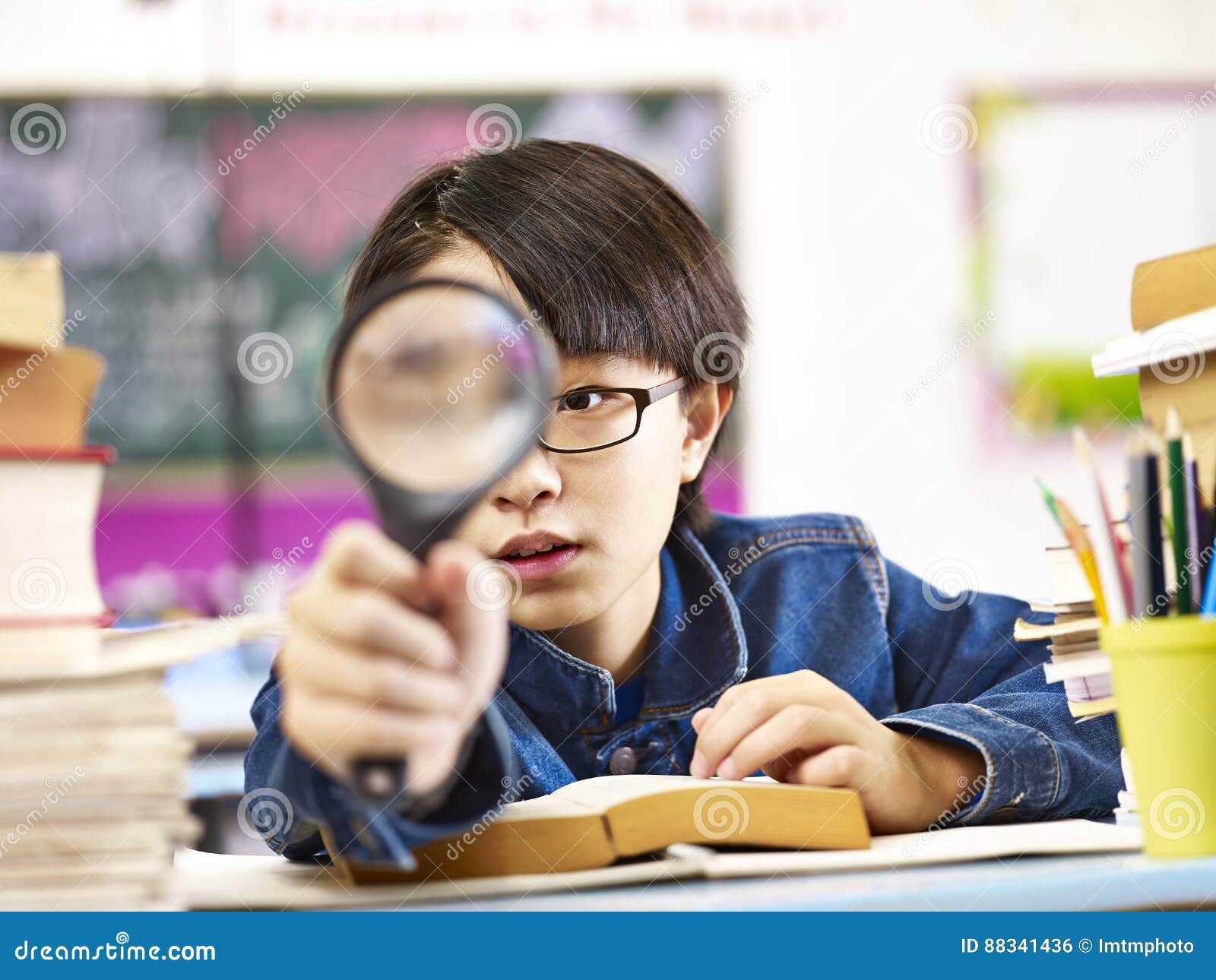 Curious Asian Pupil Holding a Magnifier in Front of One Eye Stock Photo ...