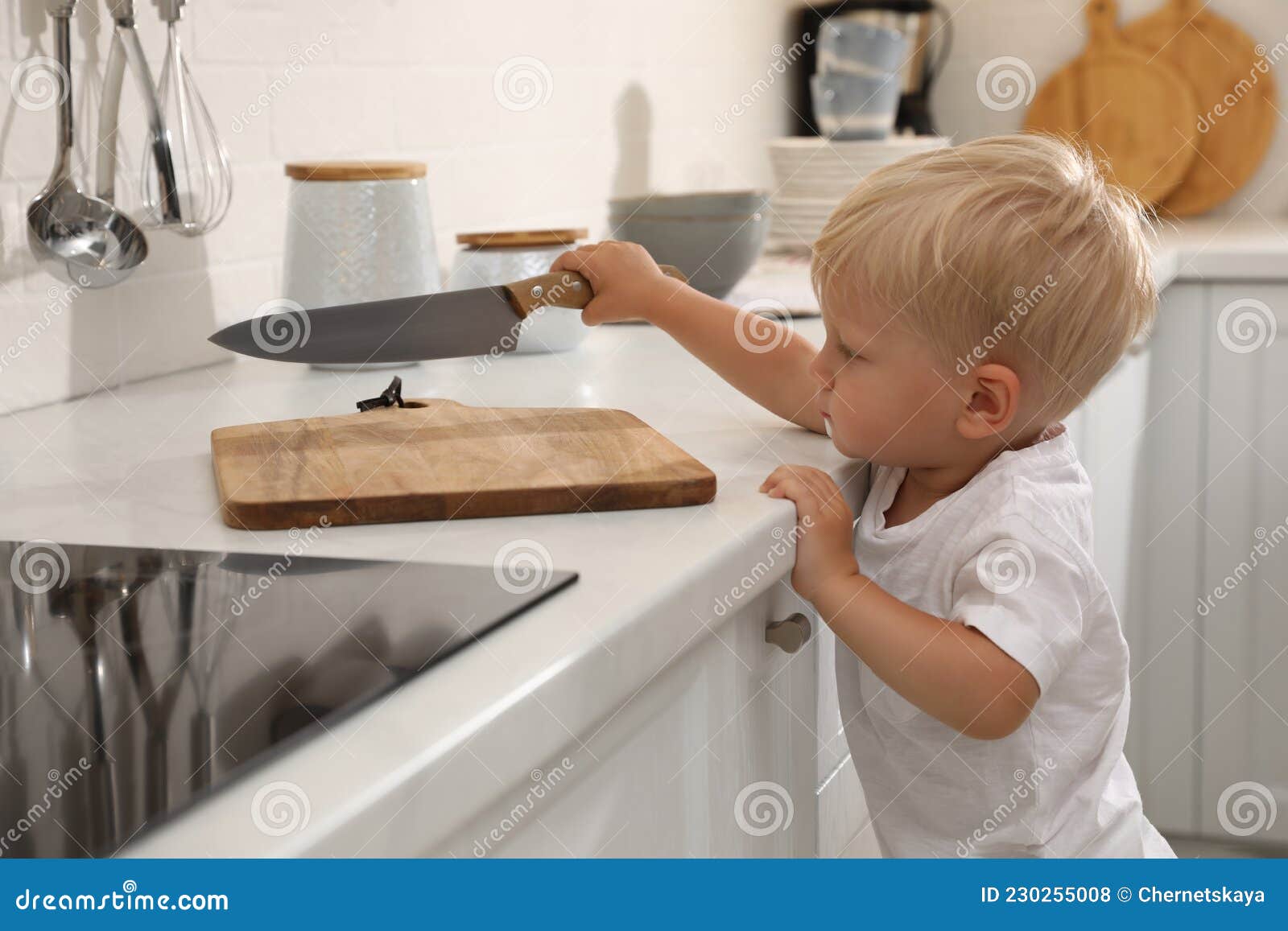 Curious Little Boy Taking Sharp Knife from Kitchen Counter Stock Photo ...