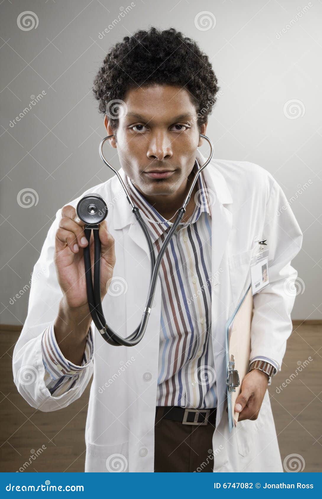 Curious Doctor in Lab Coat Holding Stethoscope Stock Photo - Image of ...