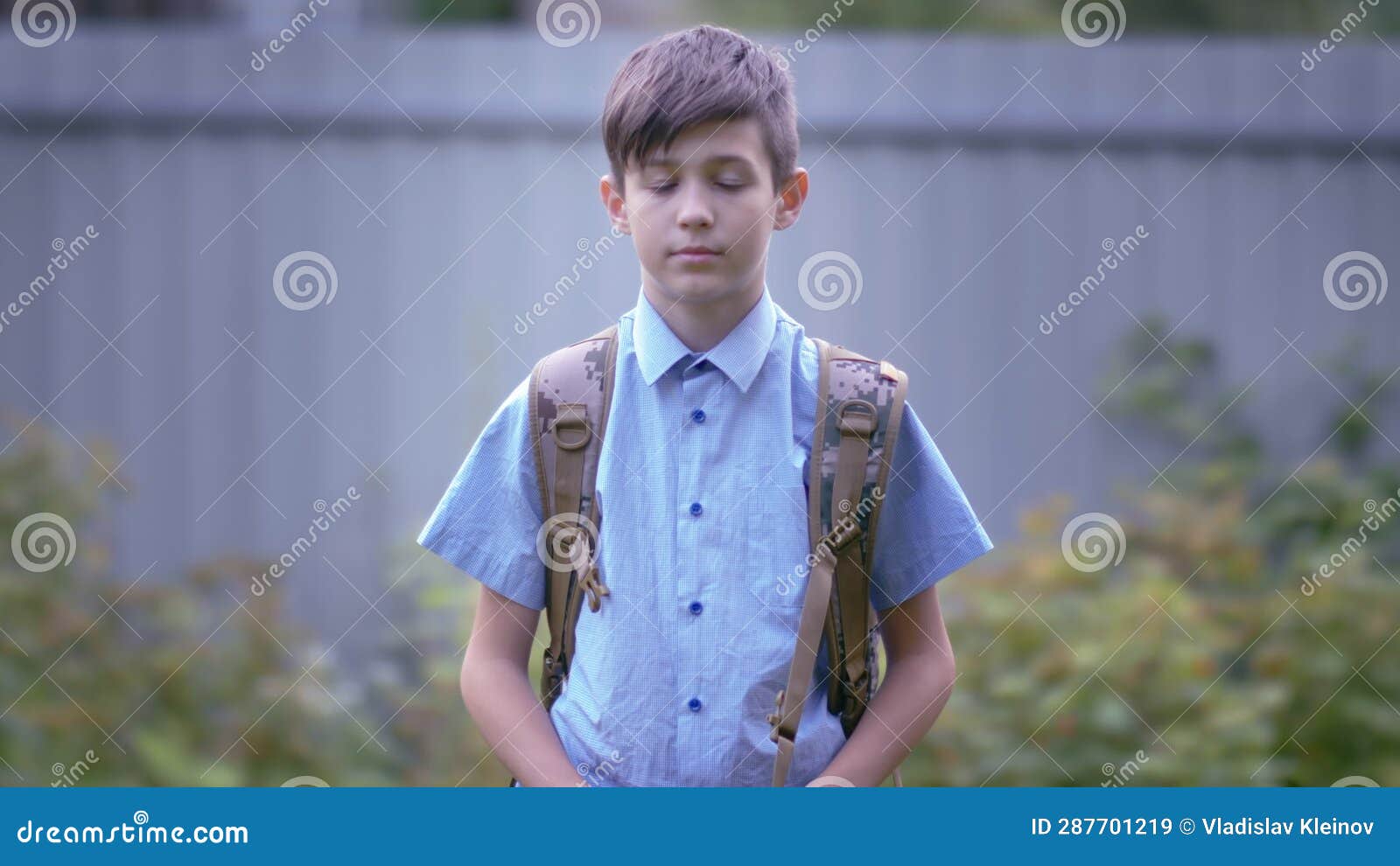 Curious Gaze: Schoolboy with Backpack Standing Outdoors, Locking Eyes ...