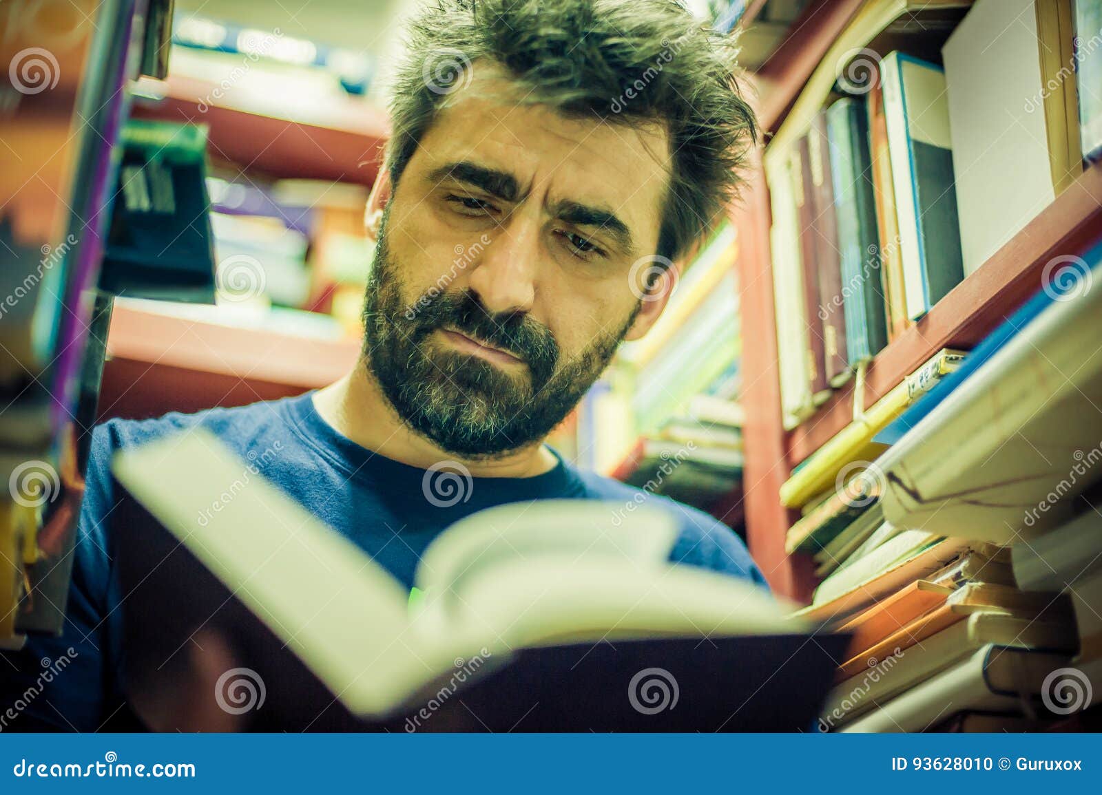 Curious Man Reading Book between the Shelves in the Library Stock Photo ...